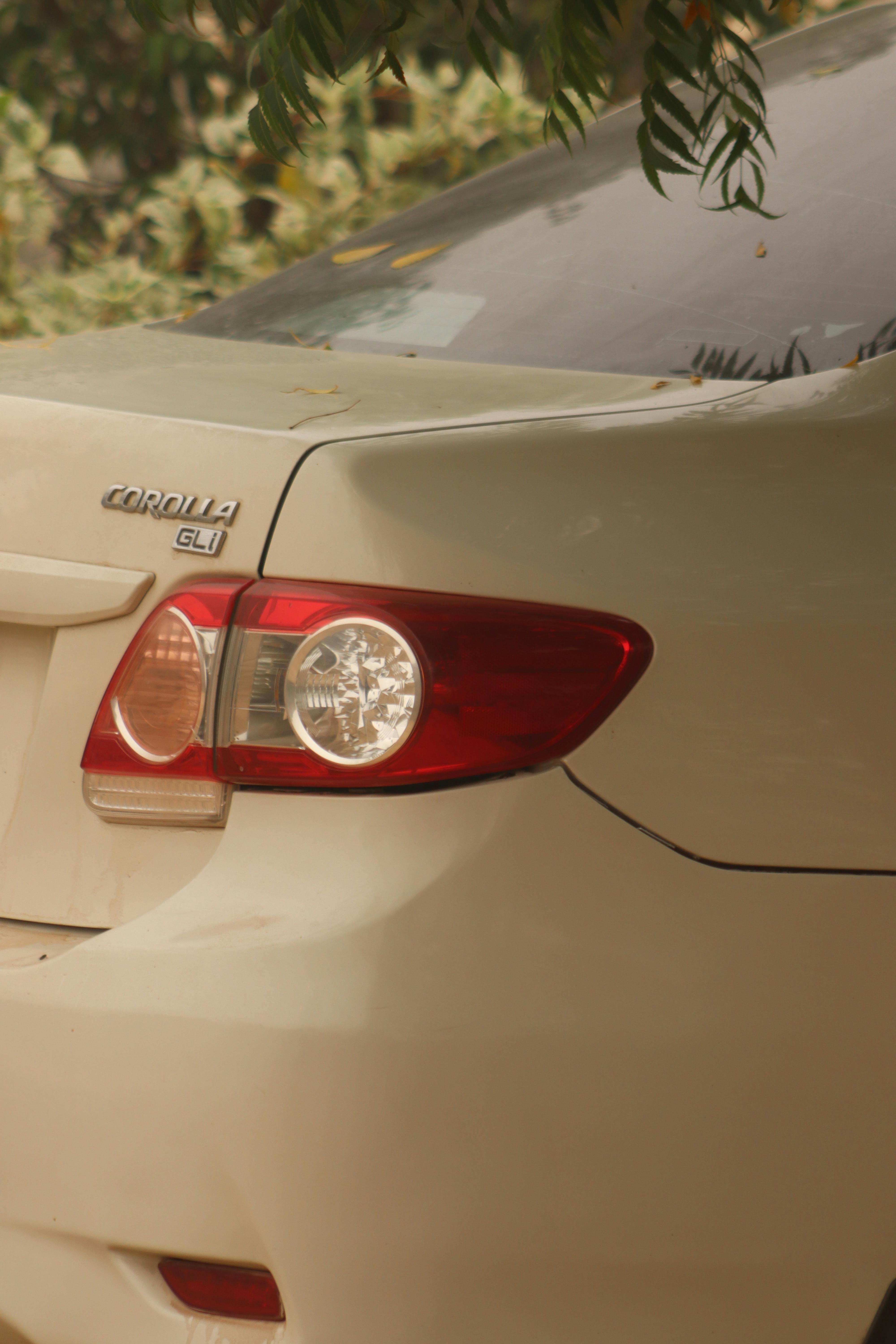 Rear View of Beige Sedan with Red Taillights · Free Stock Photo