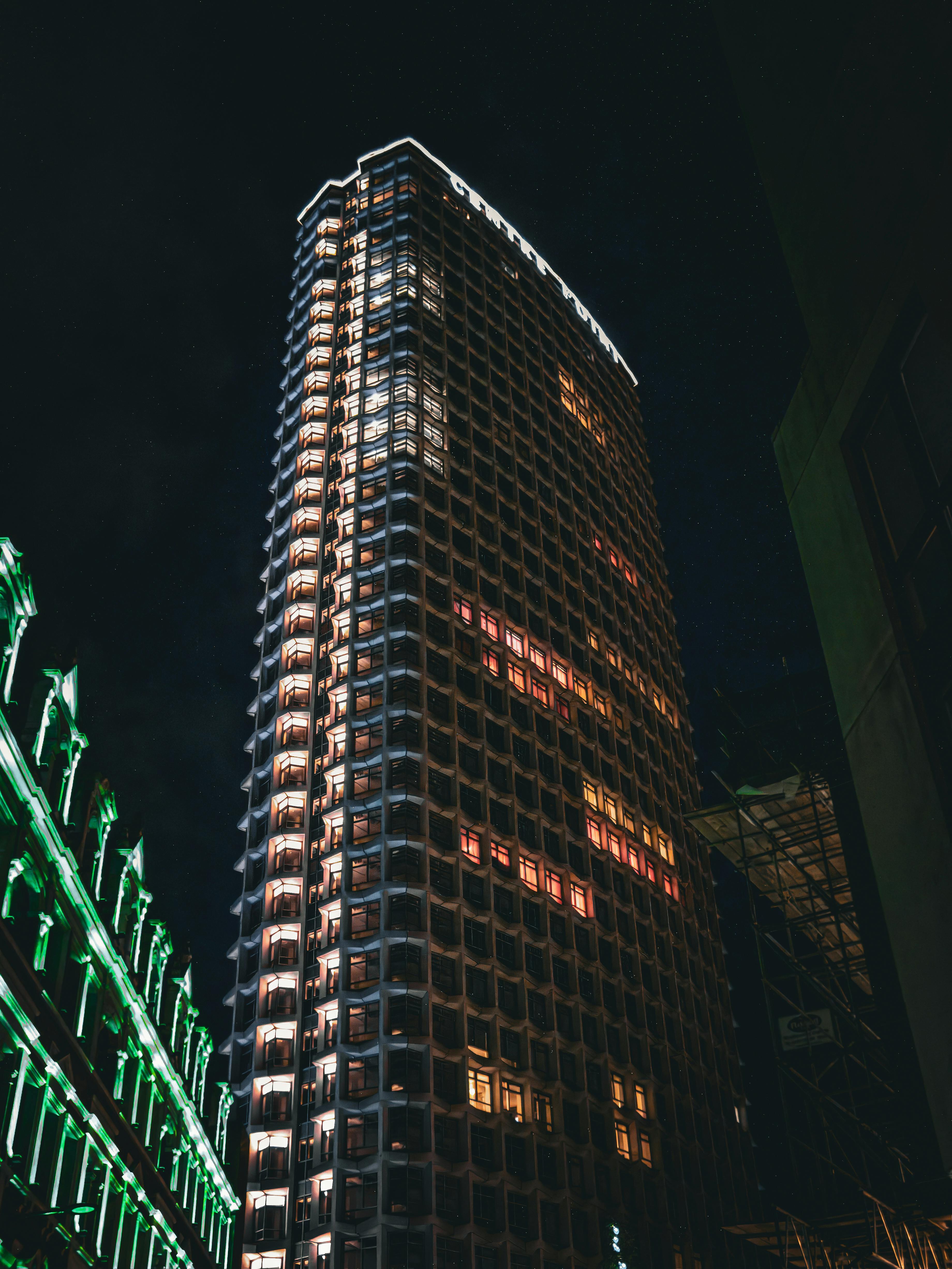 Illuminated high-rise building at night scene · Free Stock Photo