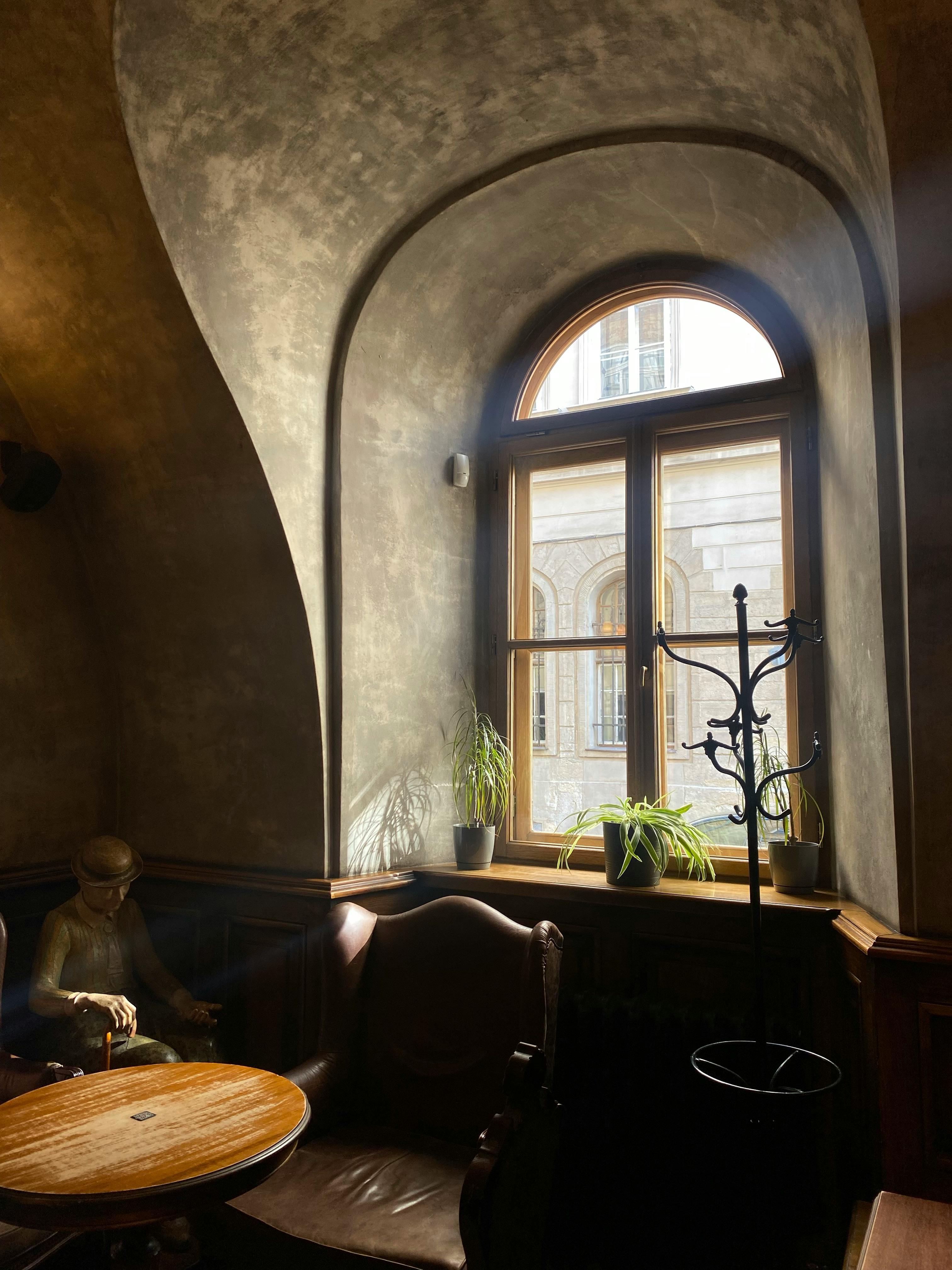 Cozy Corner in Historic Café with Arched Window · Free Stock Photo