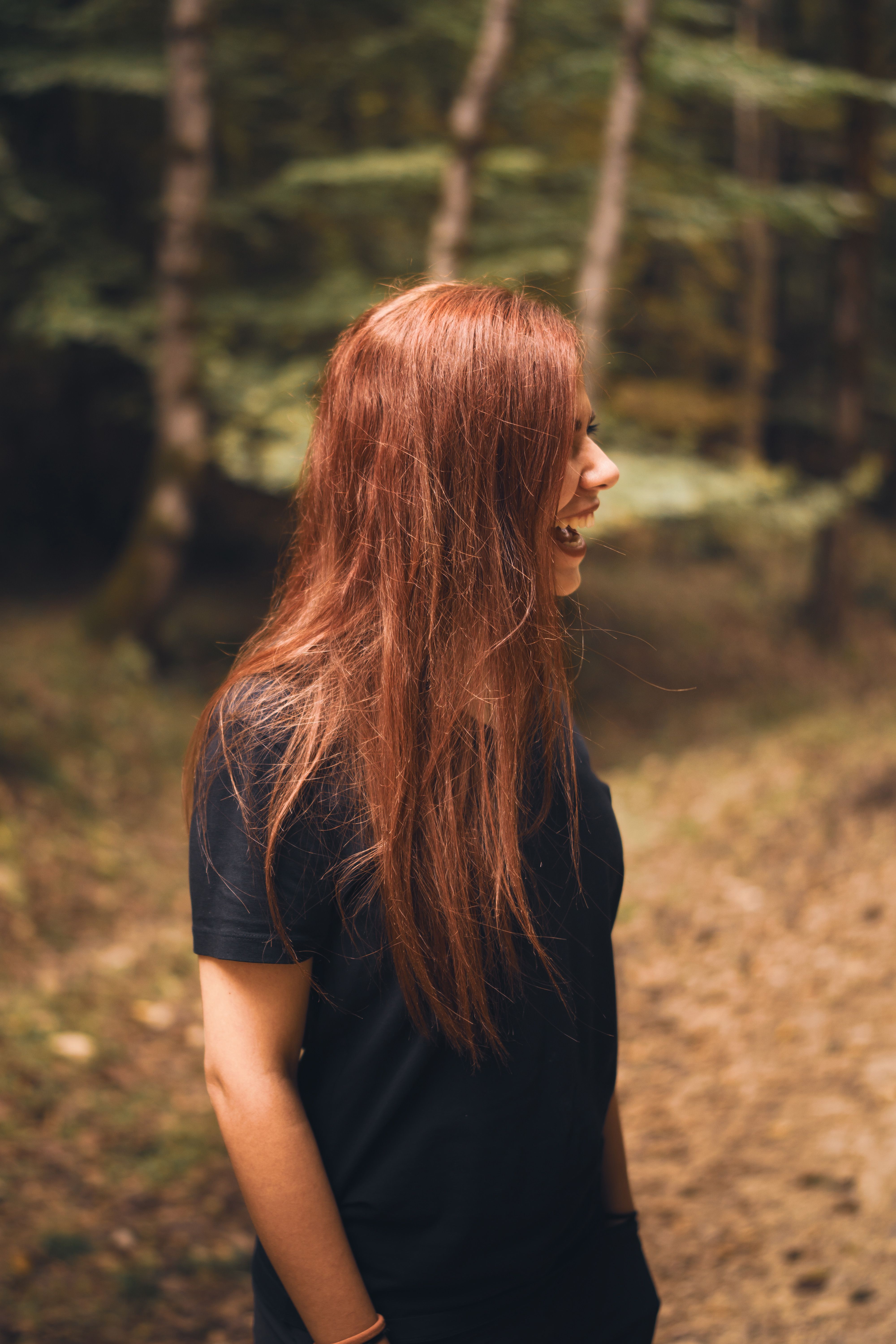 Young Woman Smiling in Lush Forest Setting · Free Stock Photo