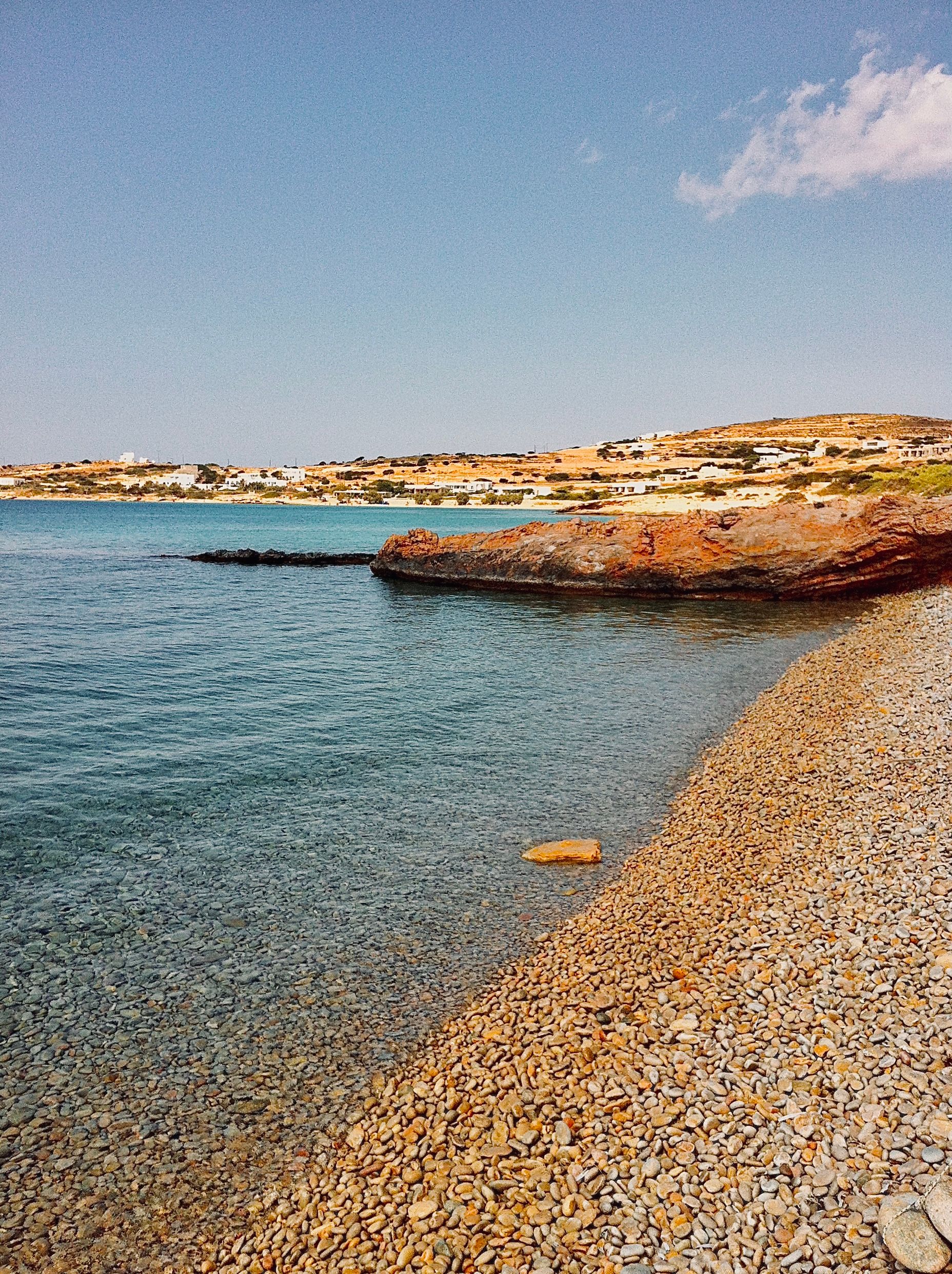 Pebble Beach with Crystal Clear Waters and Rugged Cliffs · Free Stock Photo