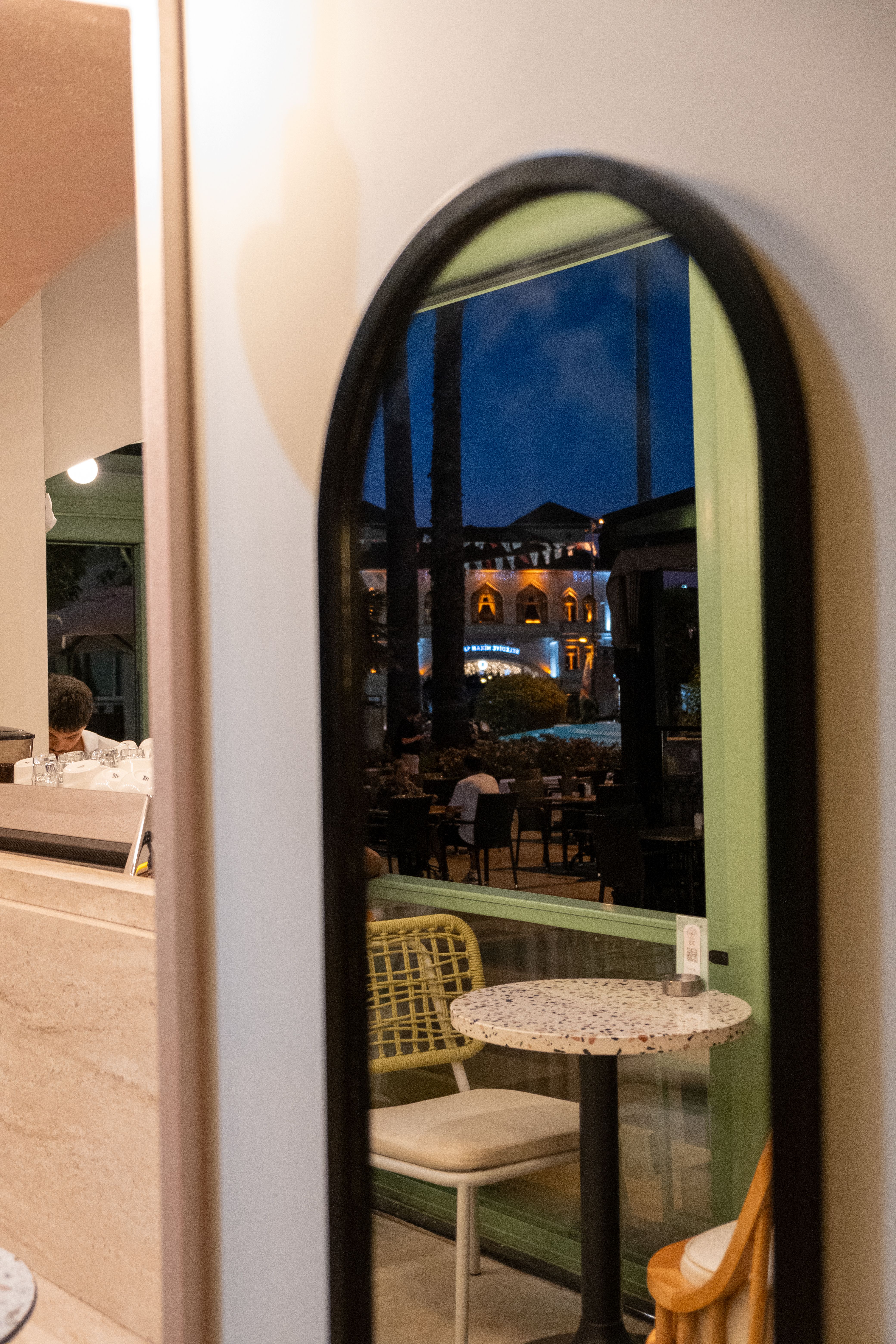 Charming Cafe Scene Reflected in Mirror at Dusk · Free Stock Photo