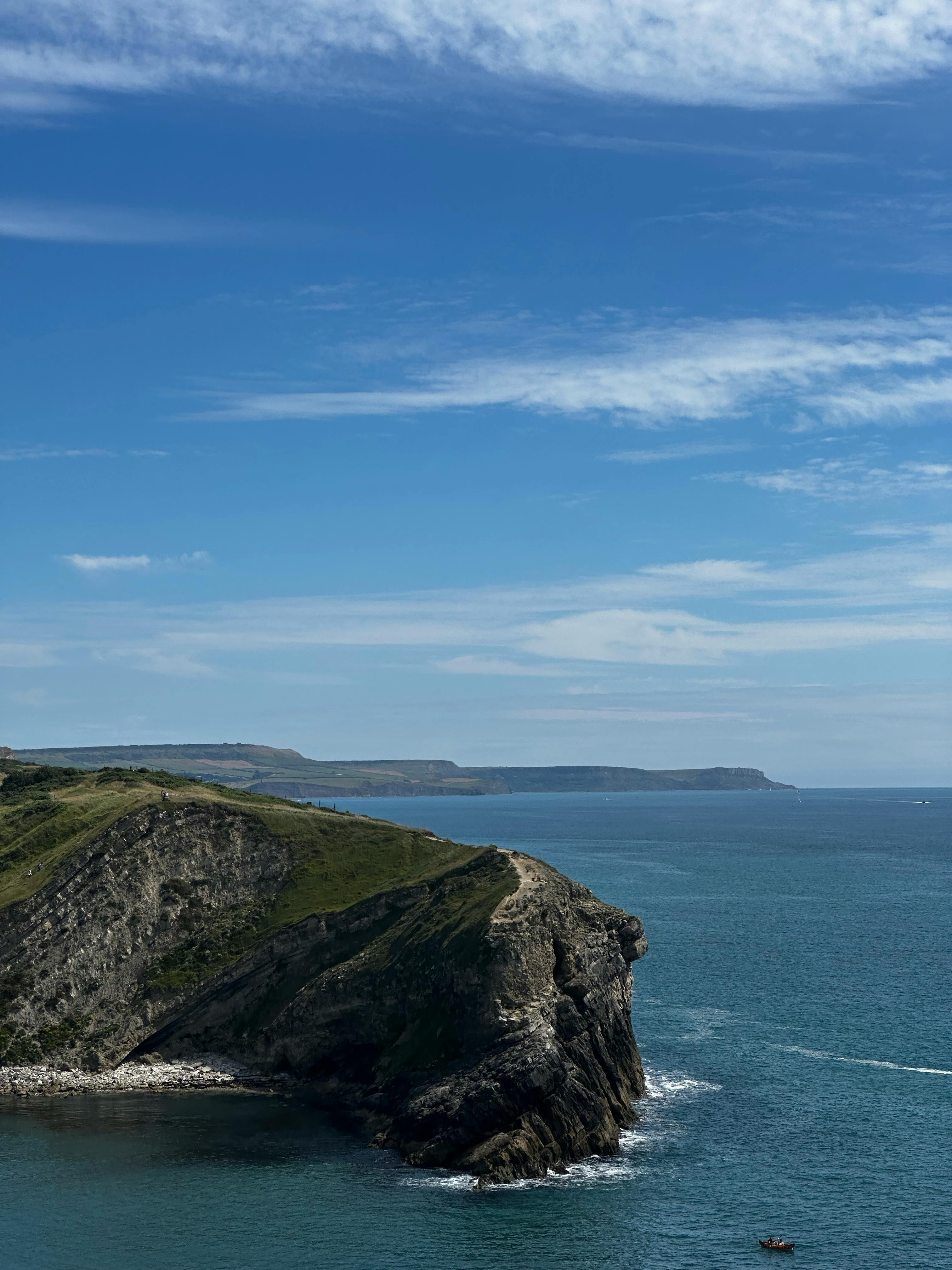 Dramatic Coastal Cliff with Blue Ocean View · Free Stock Photo