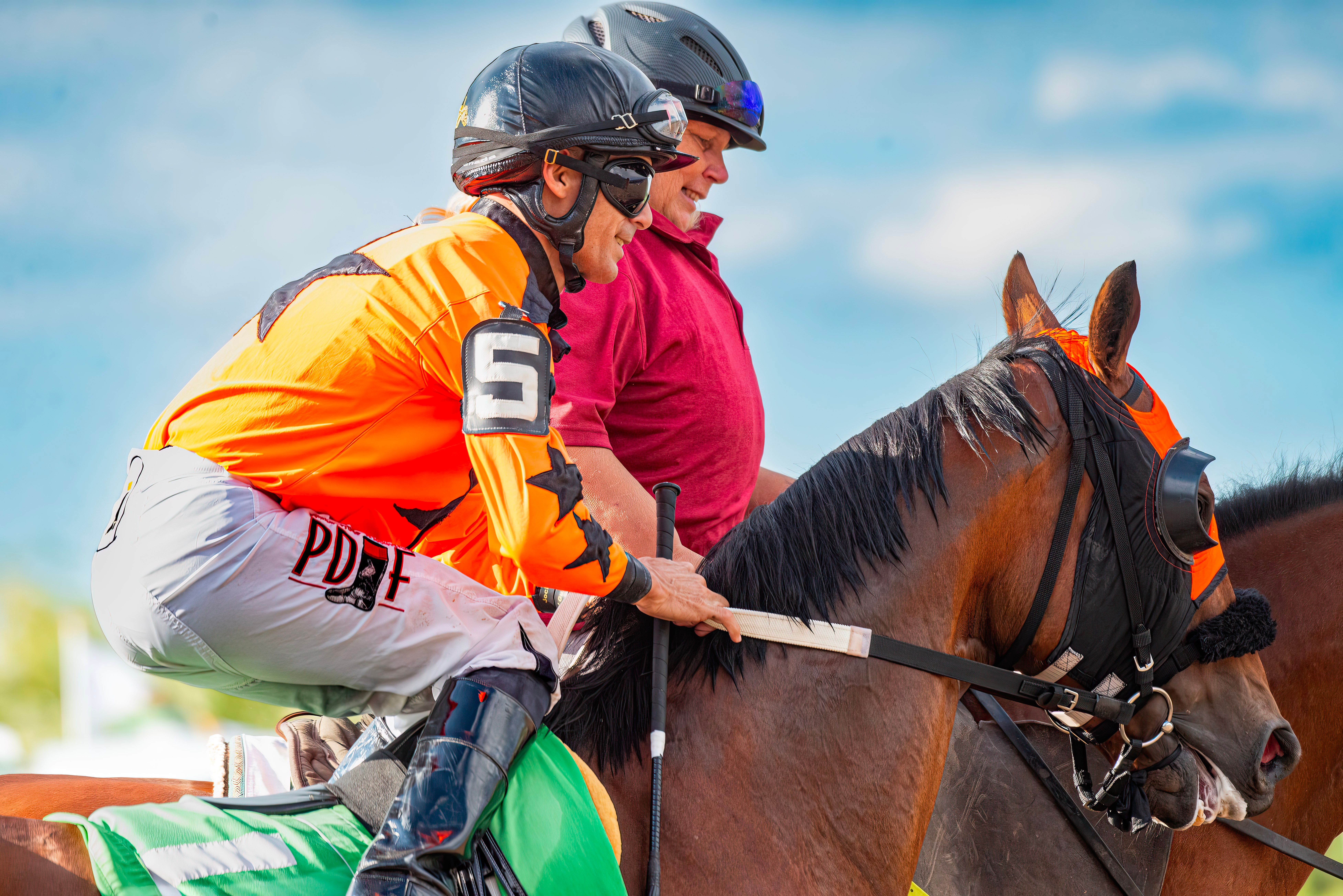 Jockey Prepares for Horse Race with Trainer Assistance · Free Stock Photo