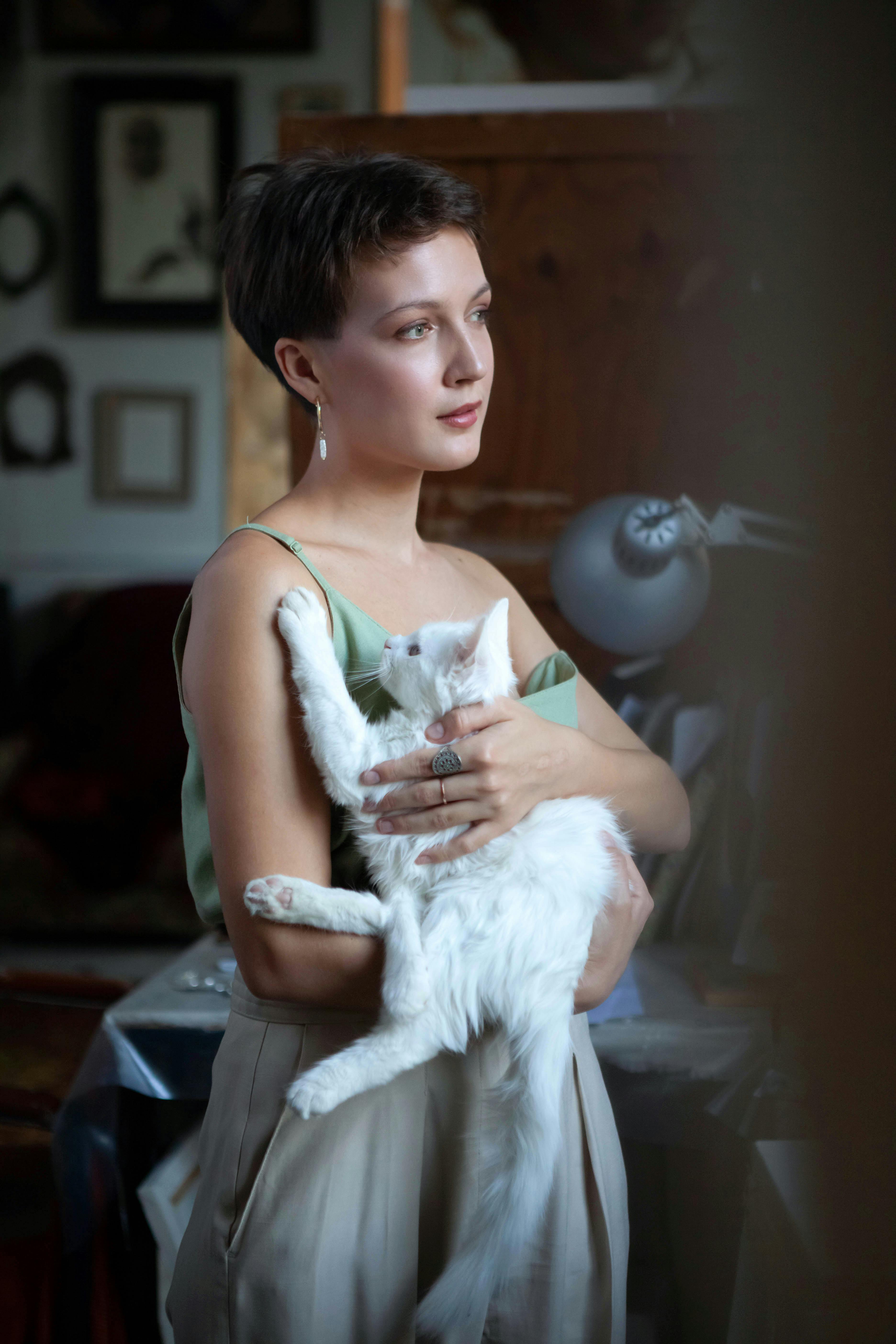 Young Woman Holding White Cat Indoors · Free Stock Photo