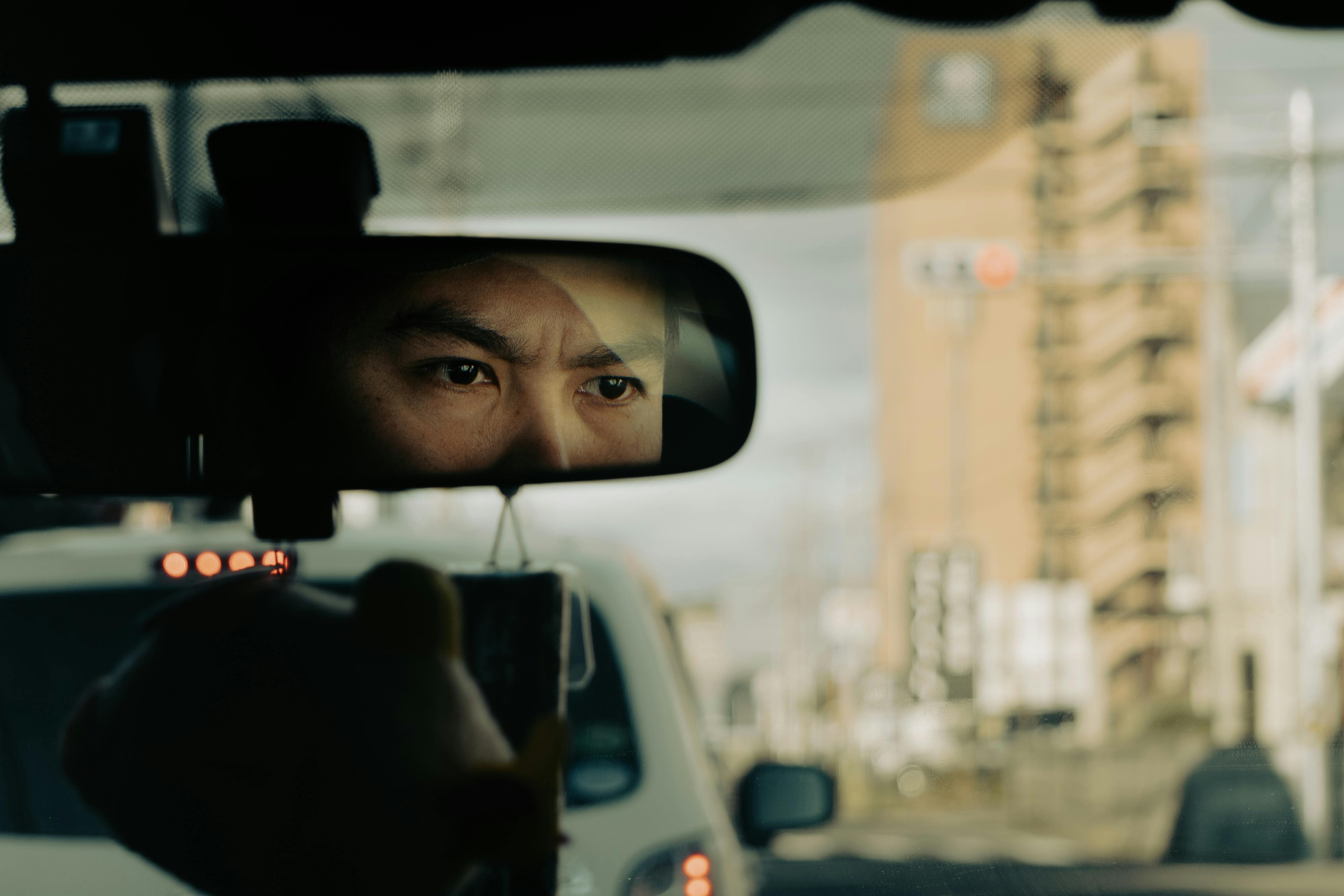 Driver's focused reflection in rearview mirror · Free Stock Photo
