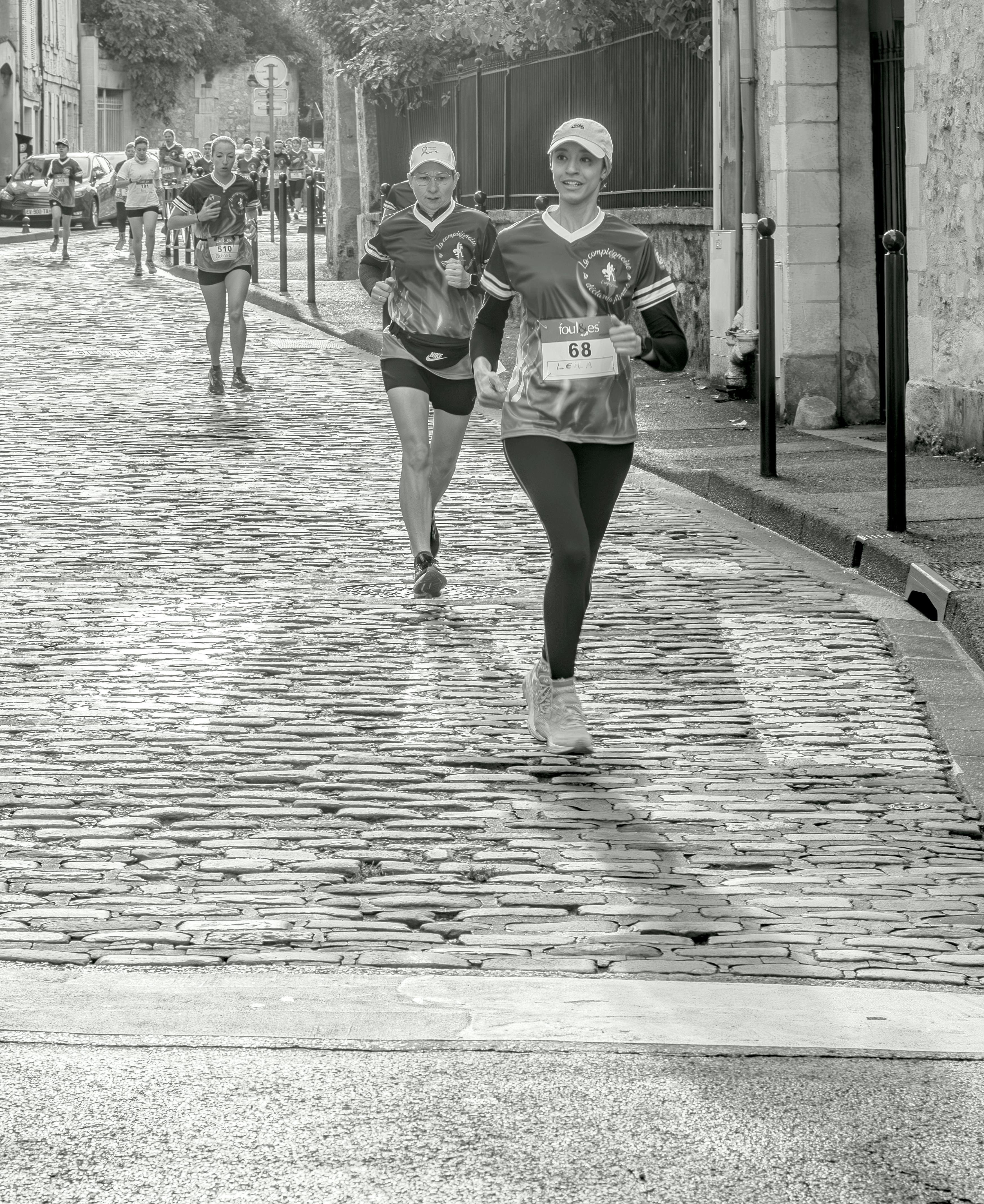 Monochrome Marathon Runners on Cobblestone Street · Free Stock Photo