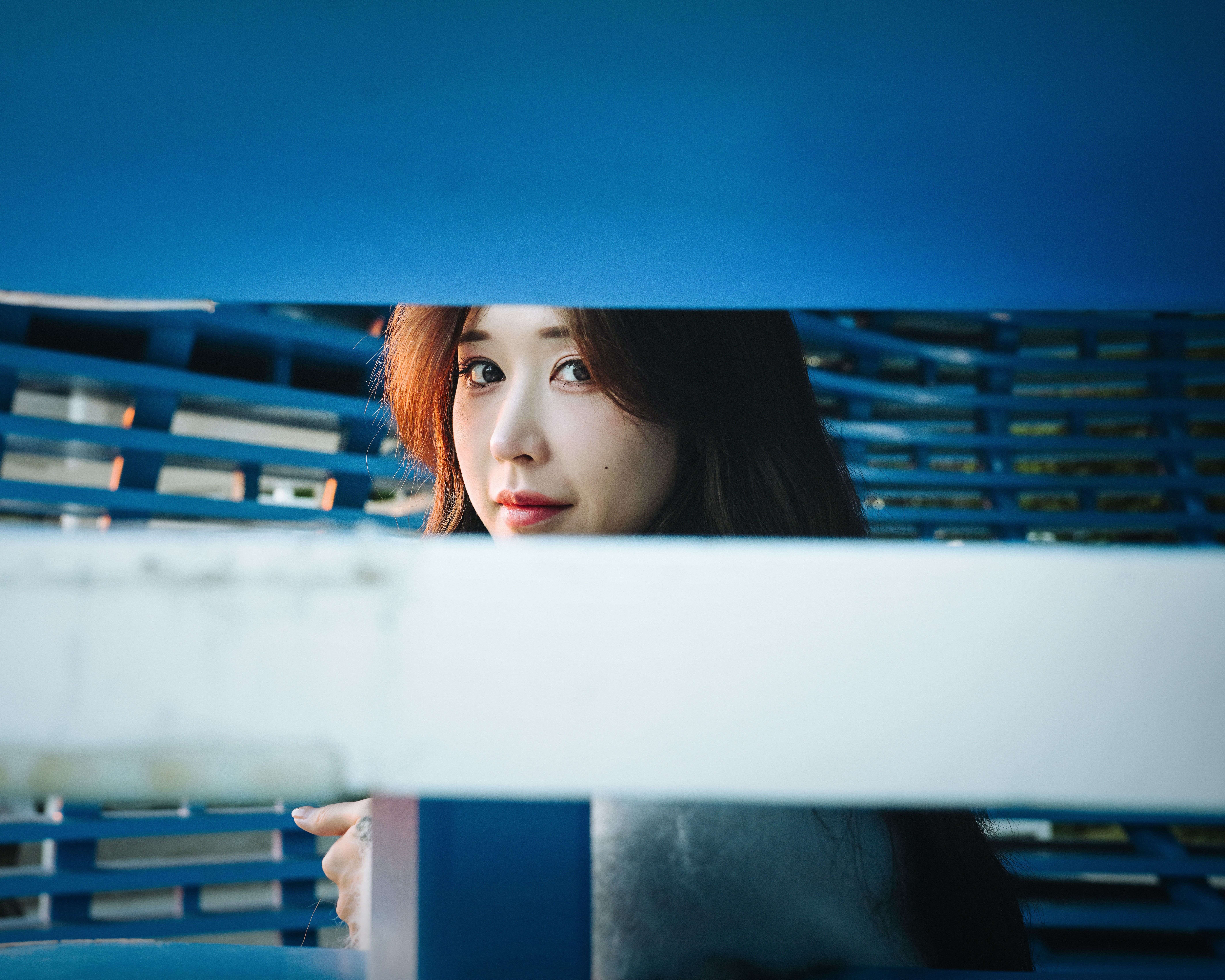 Artistic Portrait of Woman Through Blue Structure · Free Stock Photo