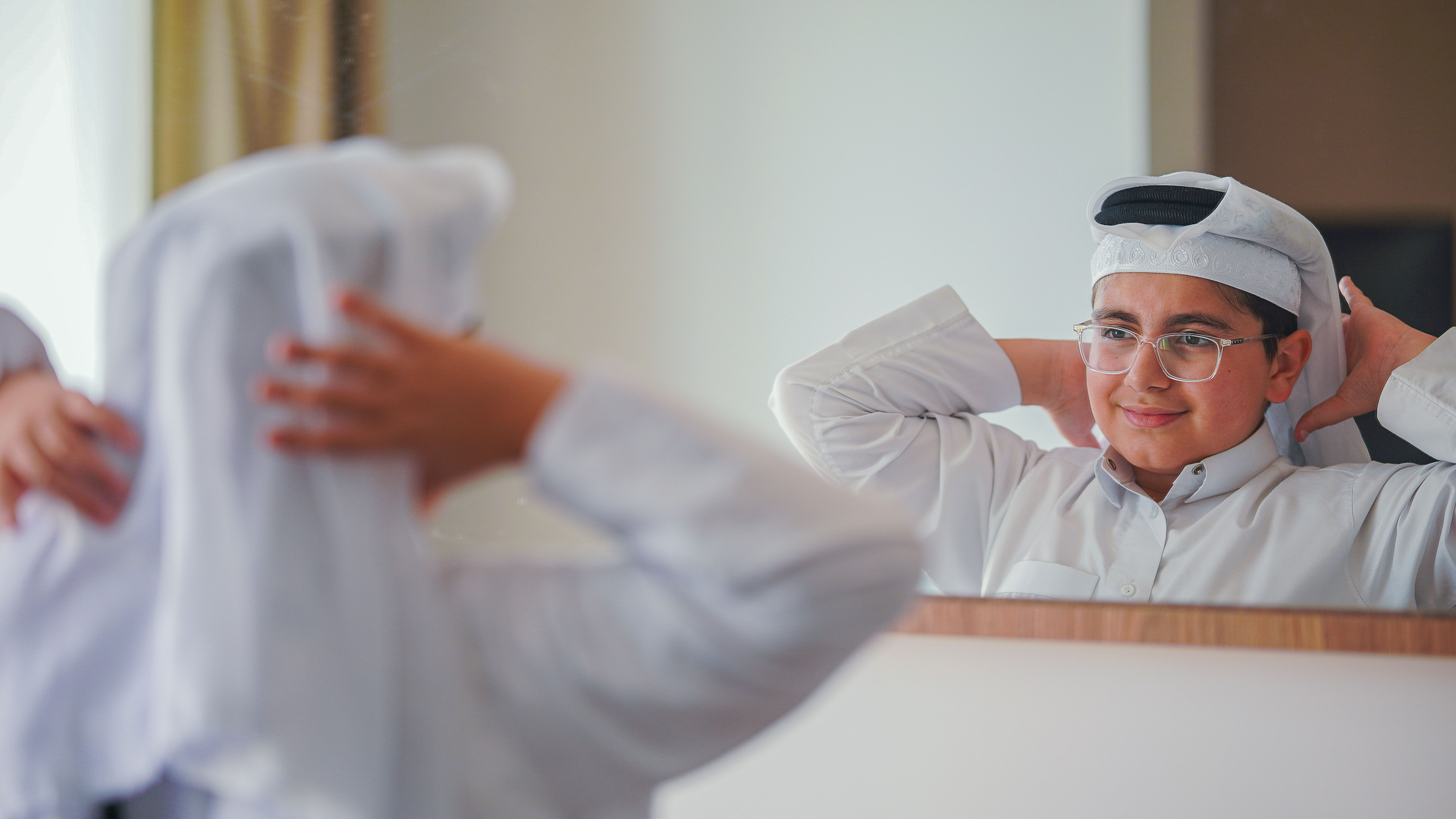 Arab Boy Adjusting Headwear in Mirror Reflection · Free Stock Photo