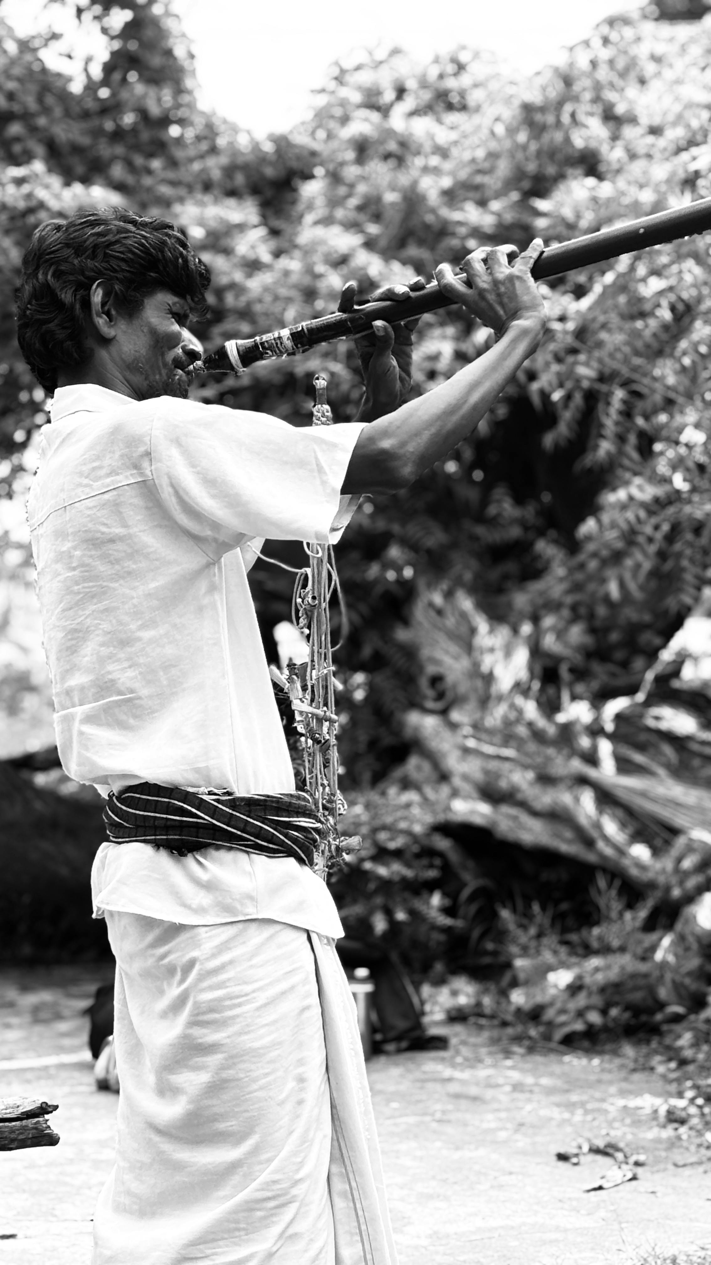 Traditional Musician Playing Wind Instrument Outdoors · Free Stock Photo