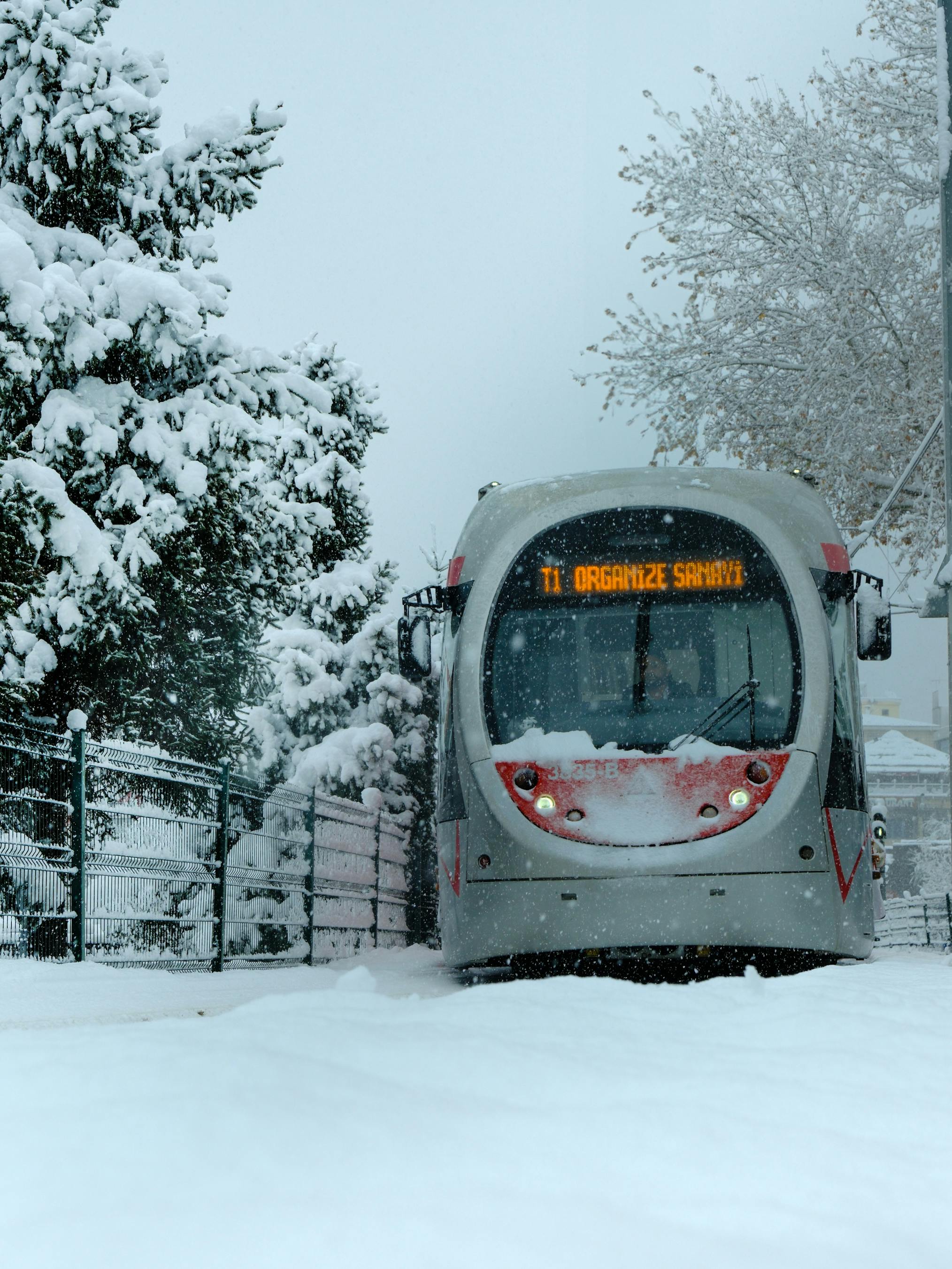 Tram Navigates Through Snow-Covered Cityscape · Free Stock Photo