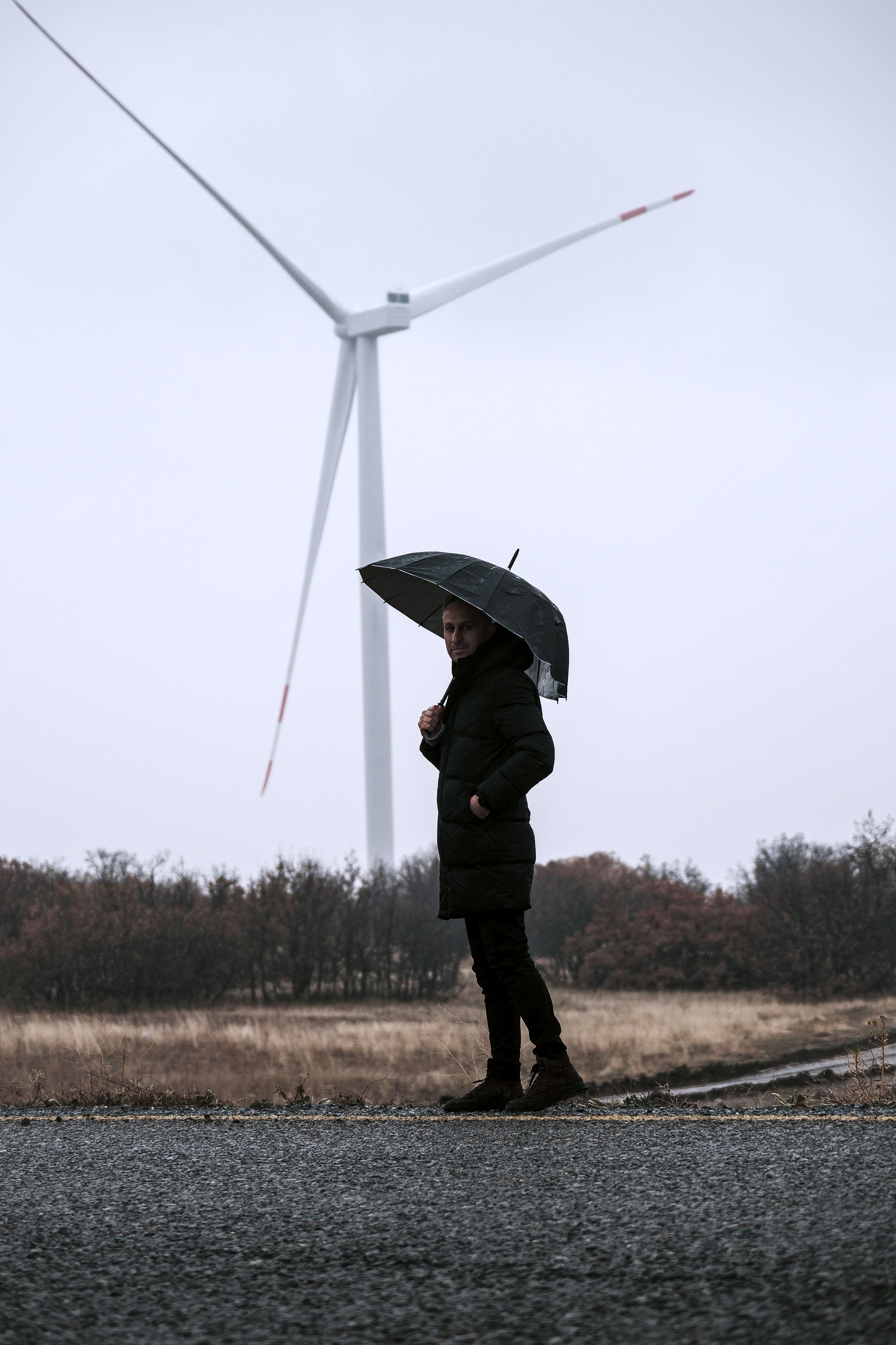 Person with Umbrella Near Wind Turbine · Free Stock Photo