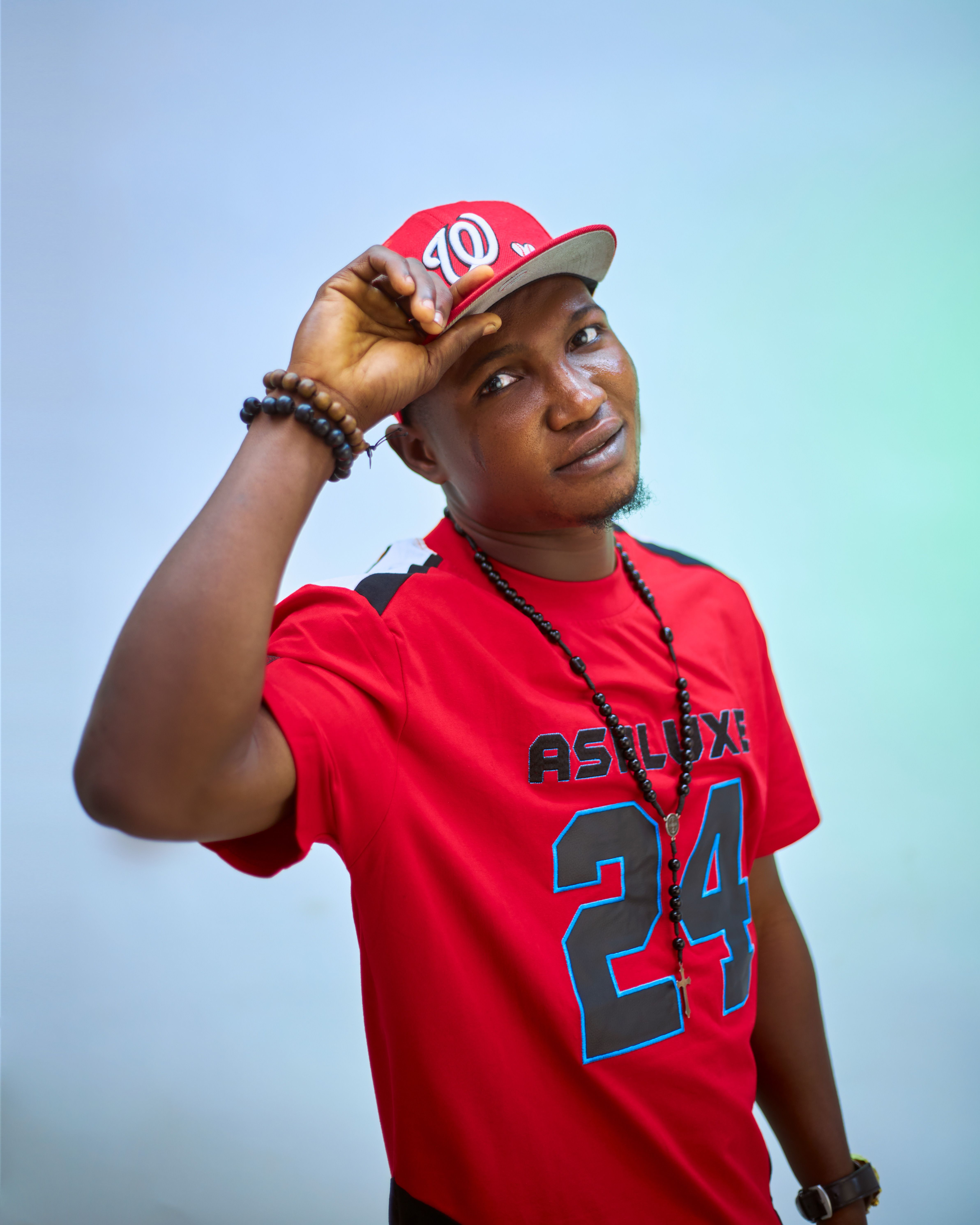 Young Man in Red Shirt and Cap Posing Confidently · Free Stock Photo