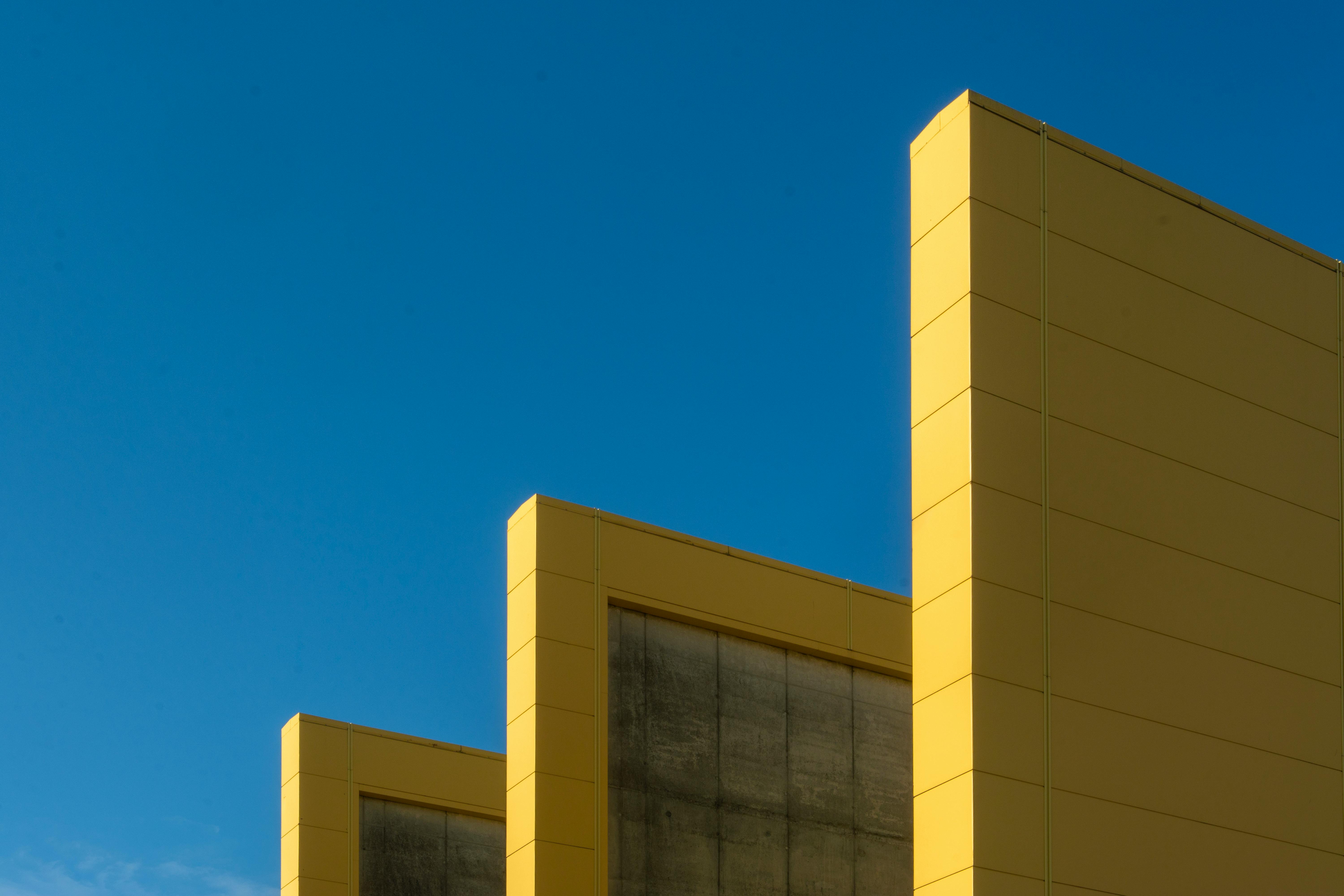 Modern Yellow Building Against Clear Blue Sky · Free Stock Photo