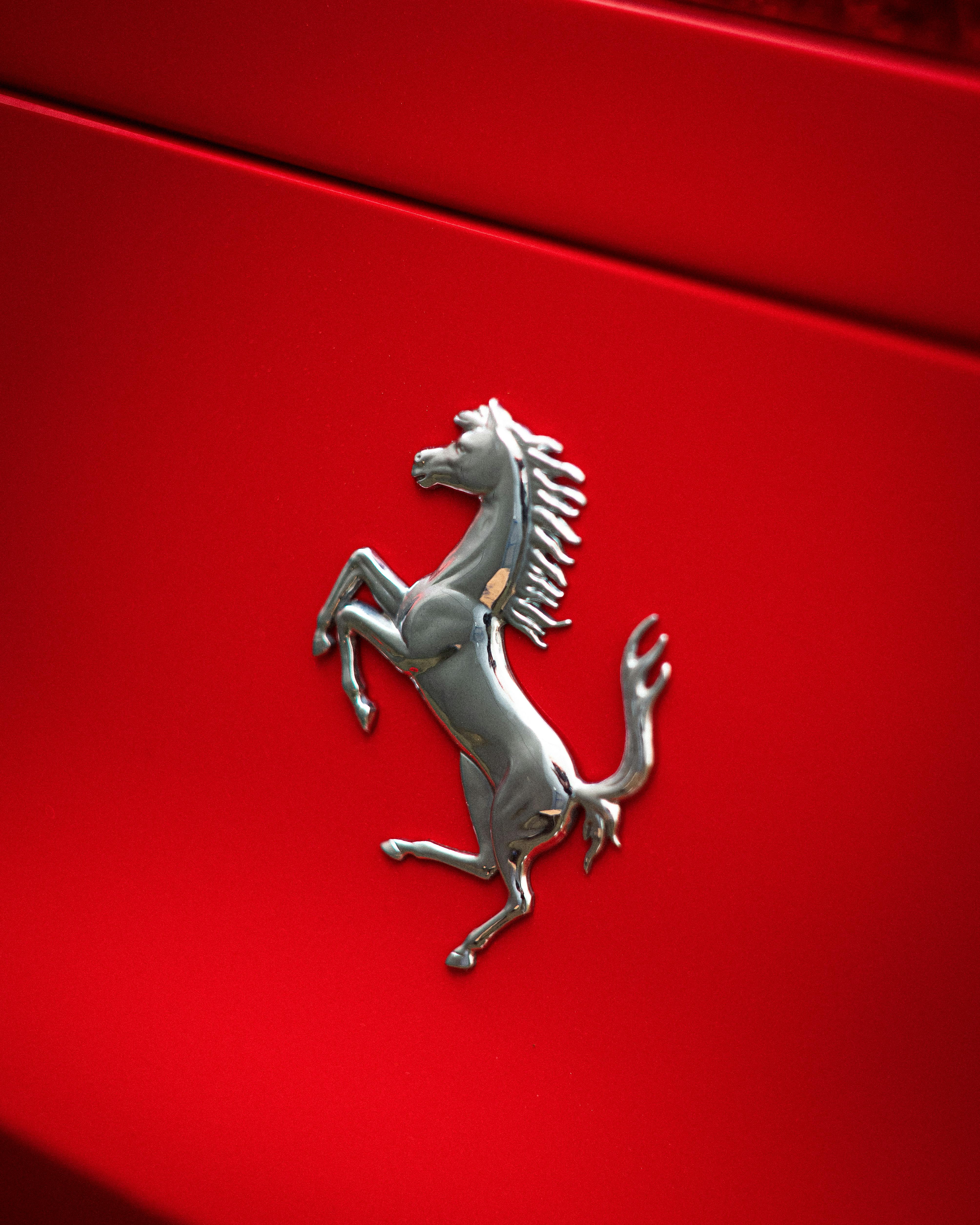 Close-Up of Iconic Red Sports Car Logo · Free Stock Photo