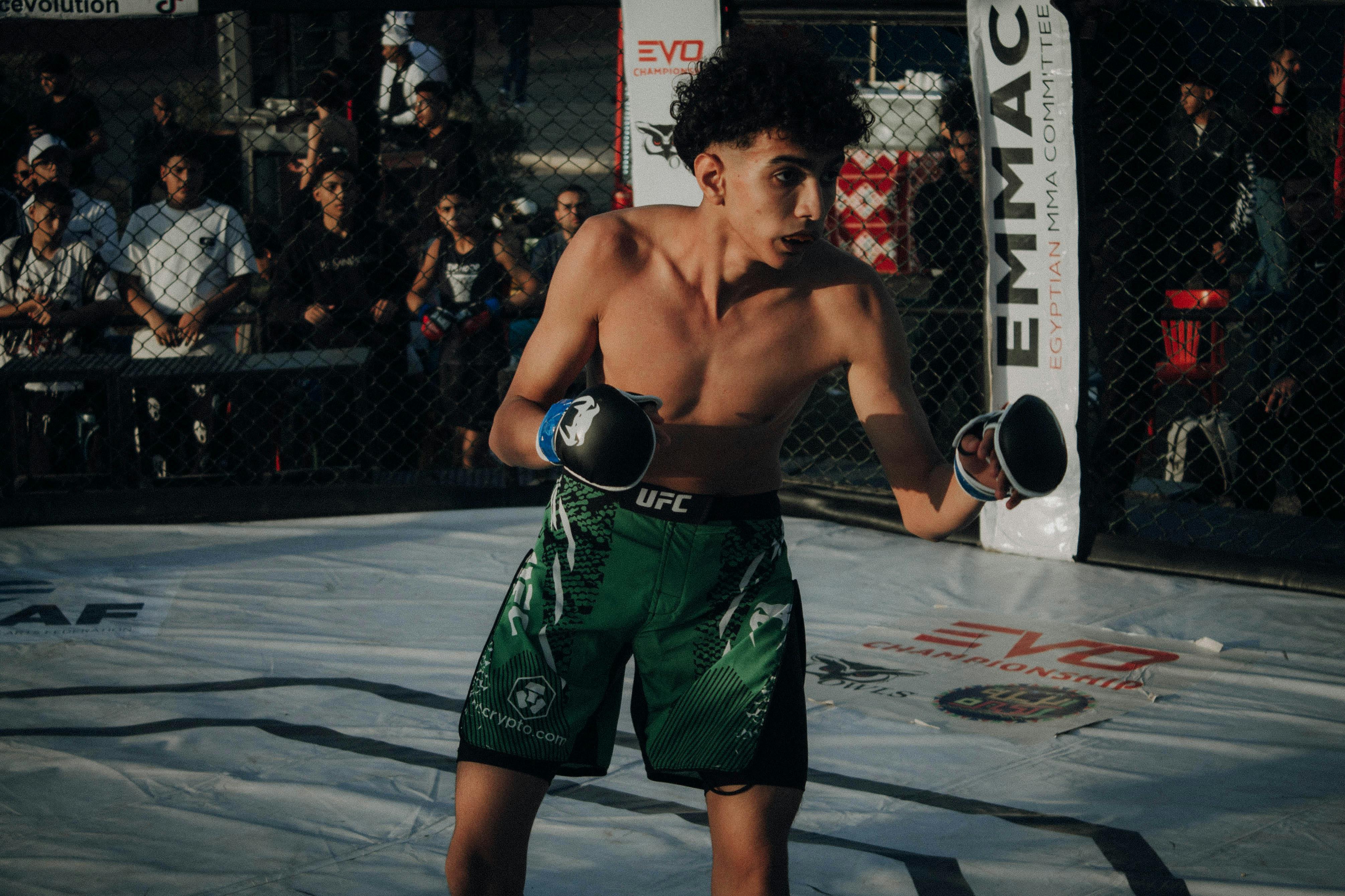 Young Fighter in MMA Cage During Match · Free Stock Photo