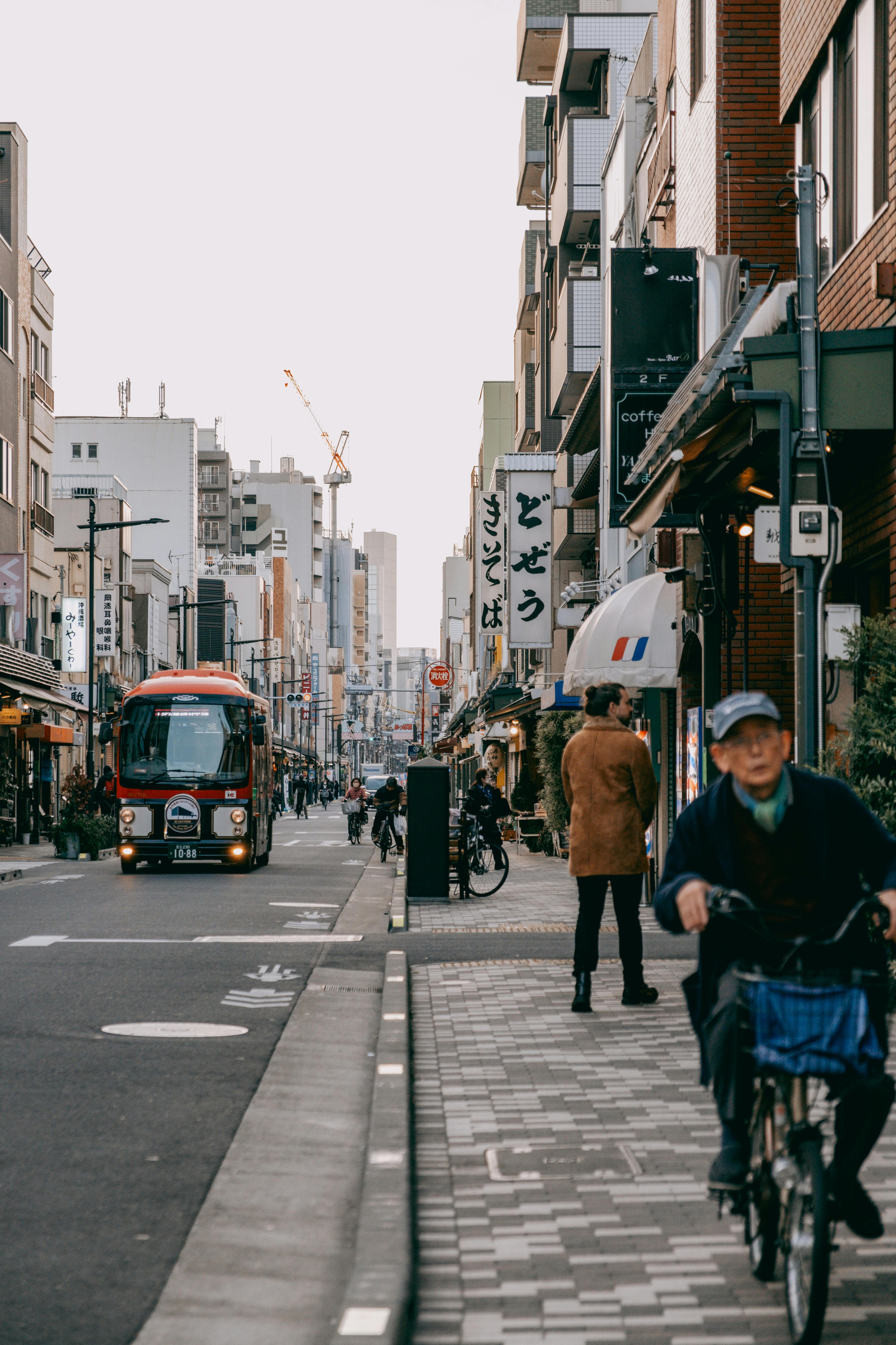 Bustling Tokyo Street with Pedestrians and Cyclists · Free Stock Photo