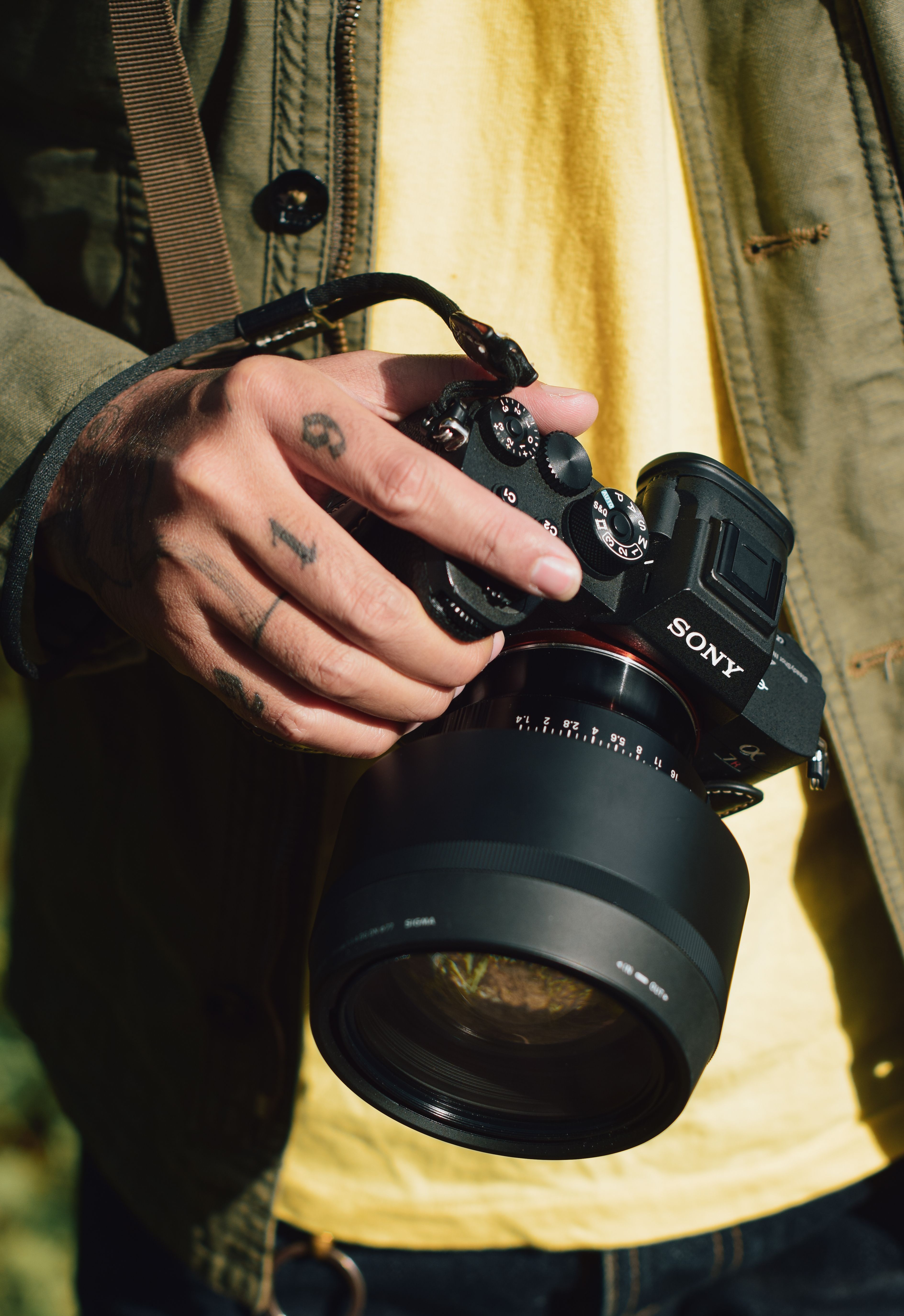 Close-up of Hand Holding Professional Camera Outdoors · Free Stock Photo