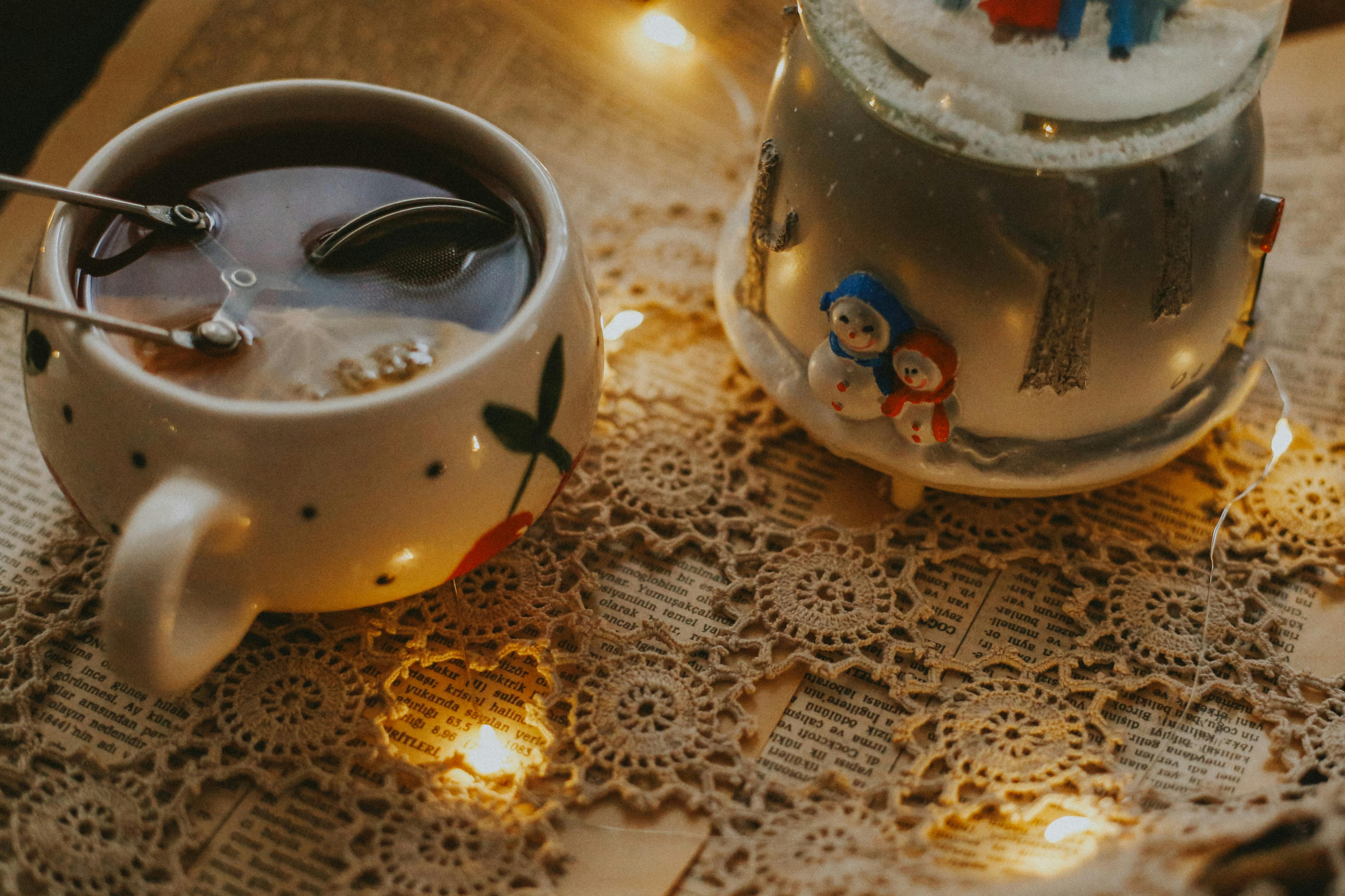 Cozy Winter Tea Setting with Snow Globe · Free Stock Photo
