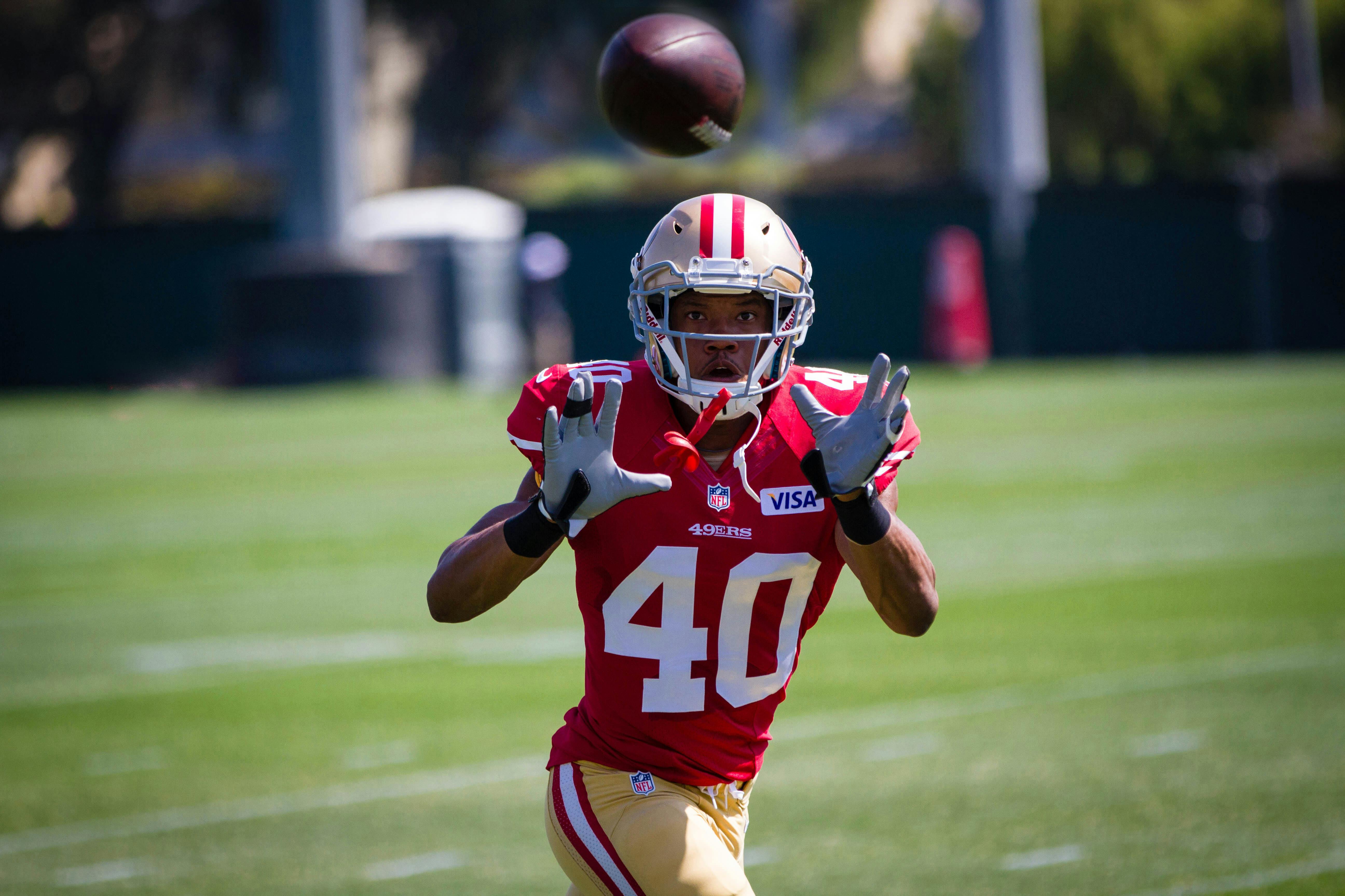 Jugador De Fútbol Americano Atrapando Una Pelota En El Campo · Foto de ...