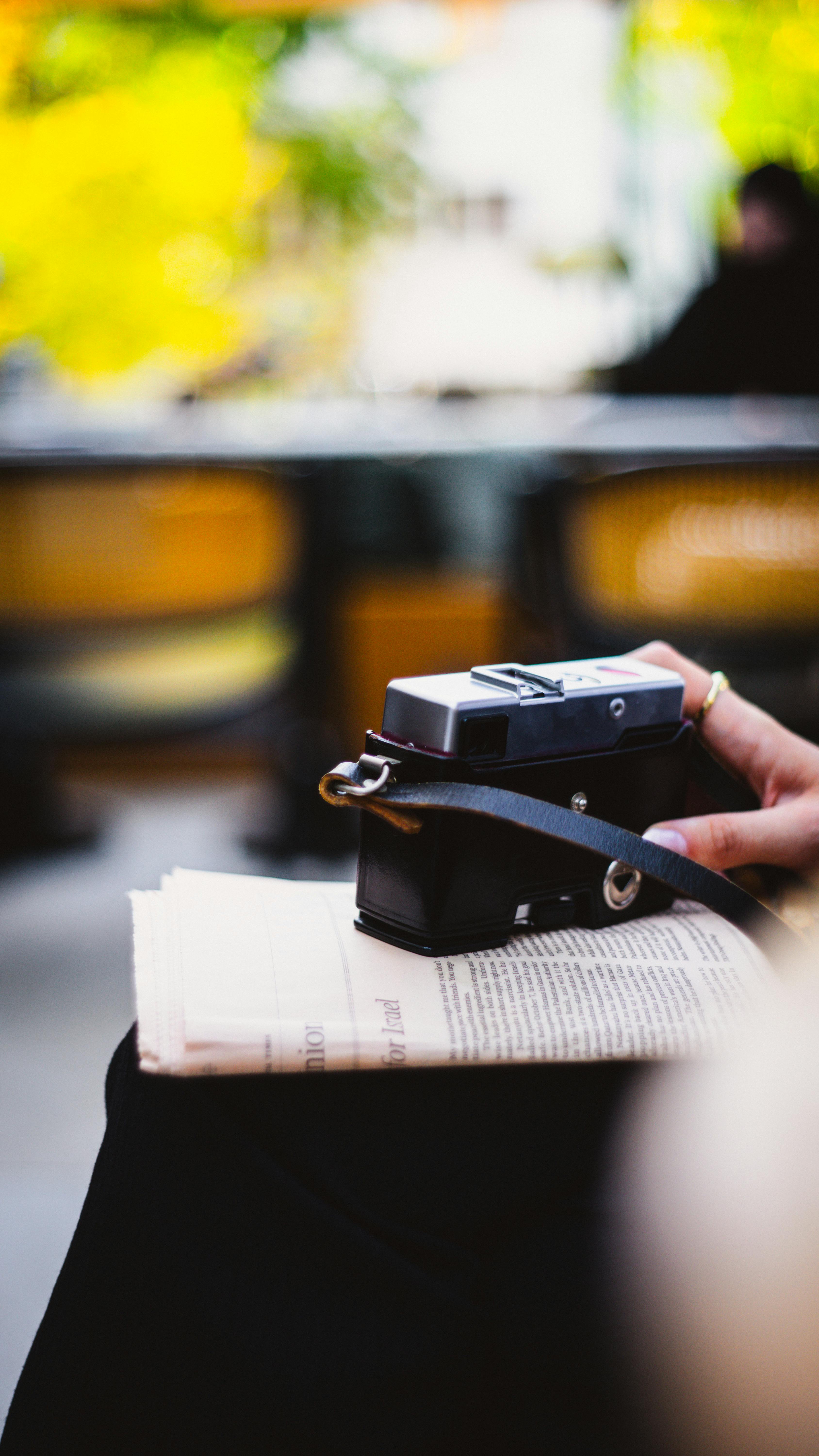 Vintage Camera and Newspaper in Relaxed Setting · Free Stock Photo