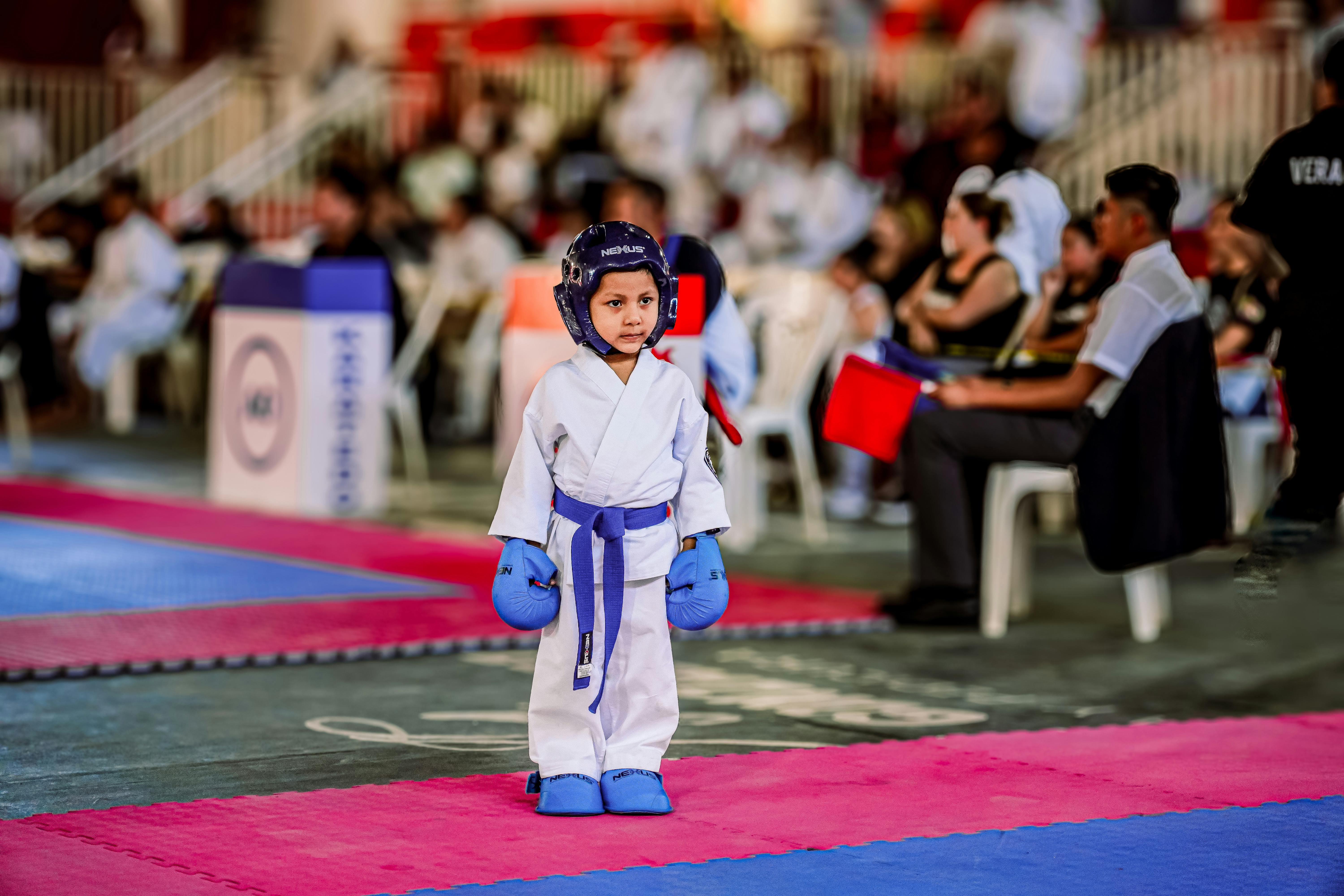 Young Karate Competitor in Blue Belt Standing on Mat · Free Stock Photo
