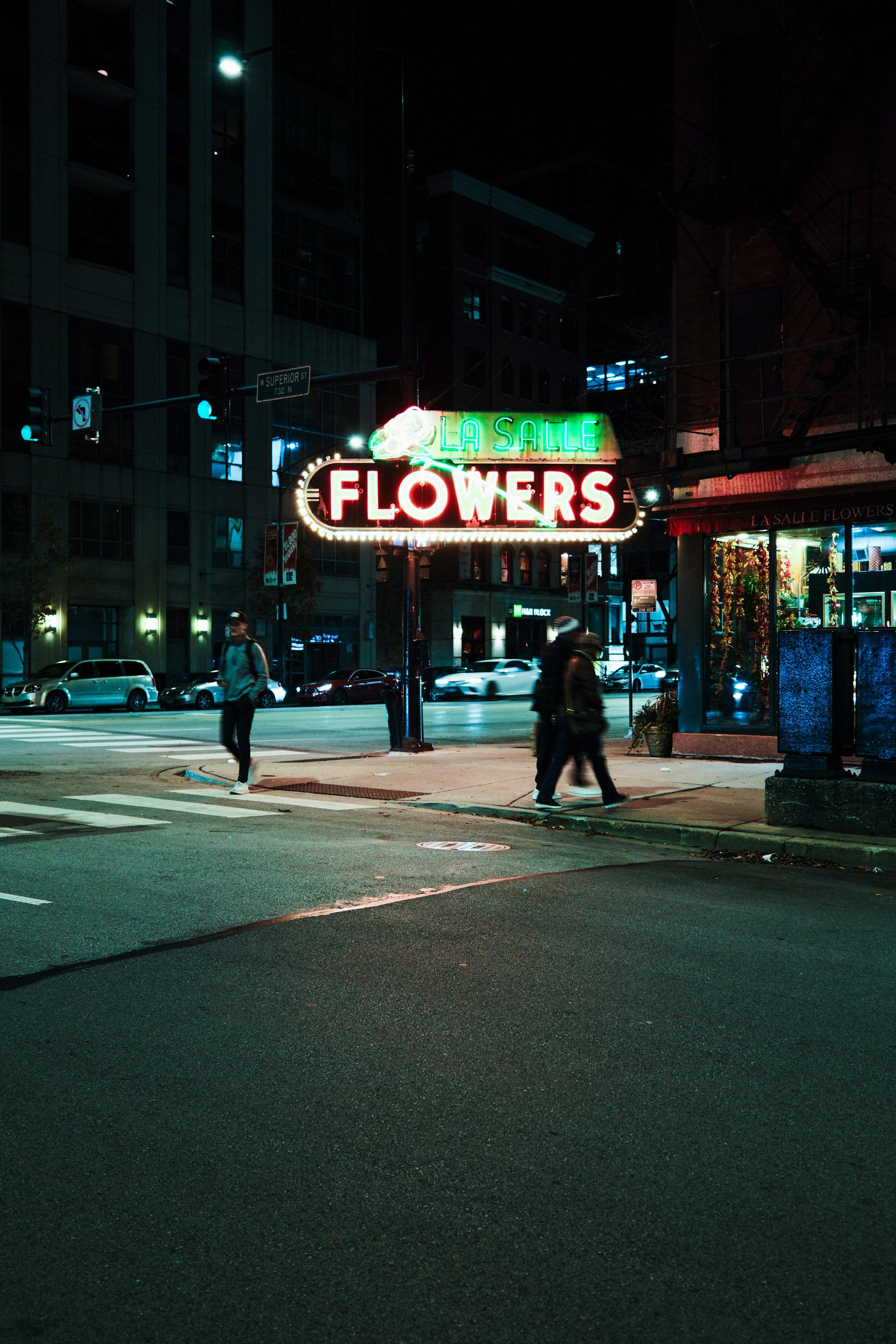 Nighttime City Street with Neon Flower Signage · Free Stock Photo
