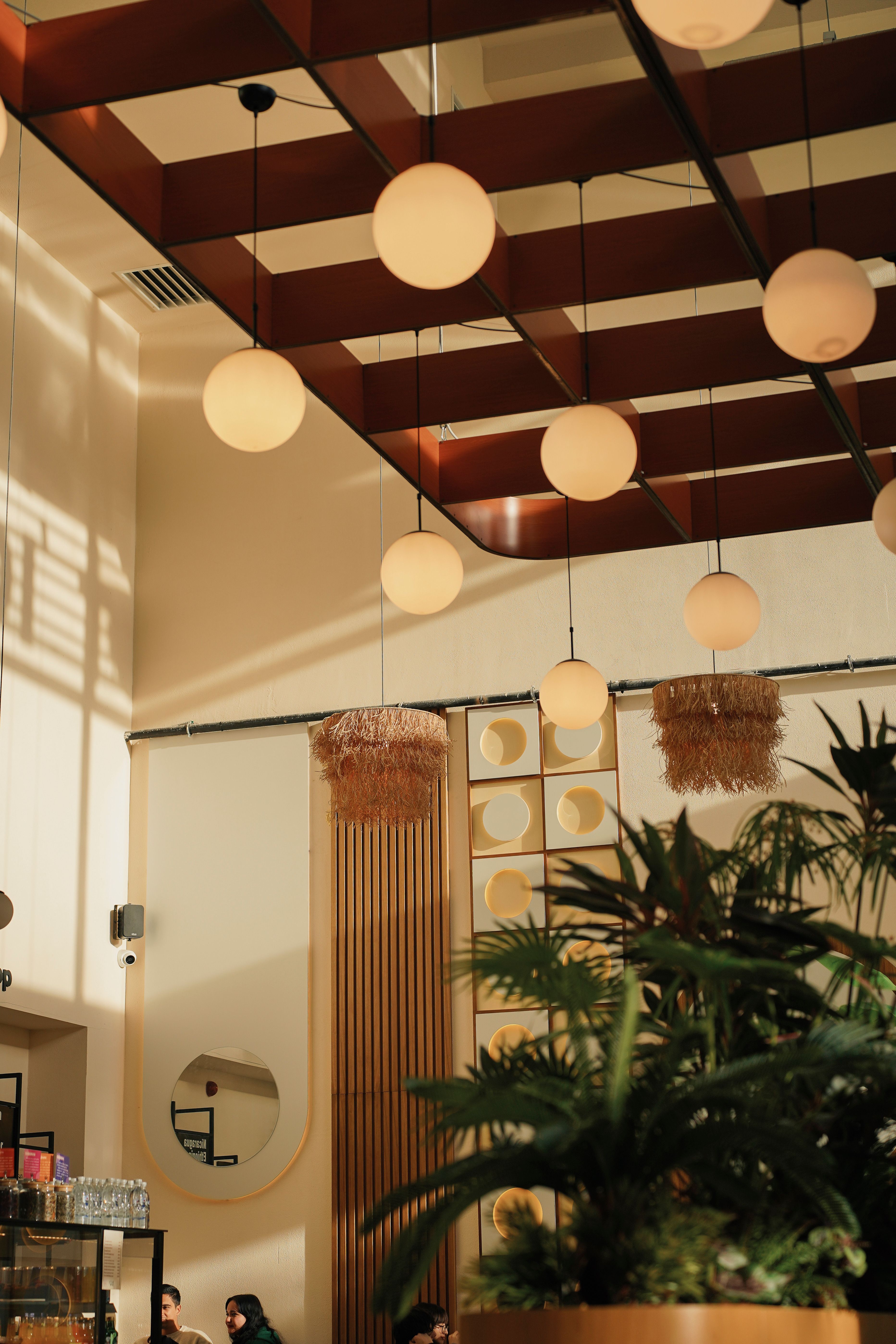 Modern Cafe Interior with Hanging Lights and Plants · Free Stock Photo