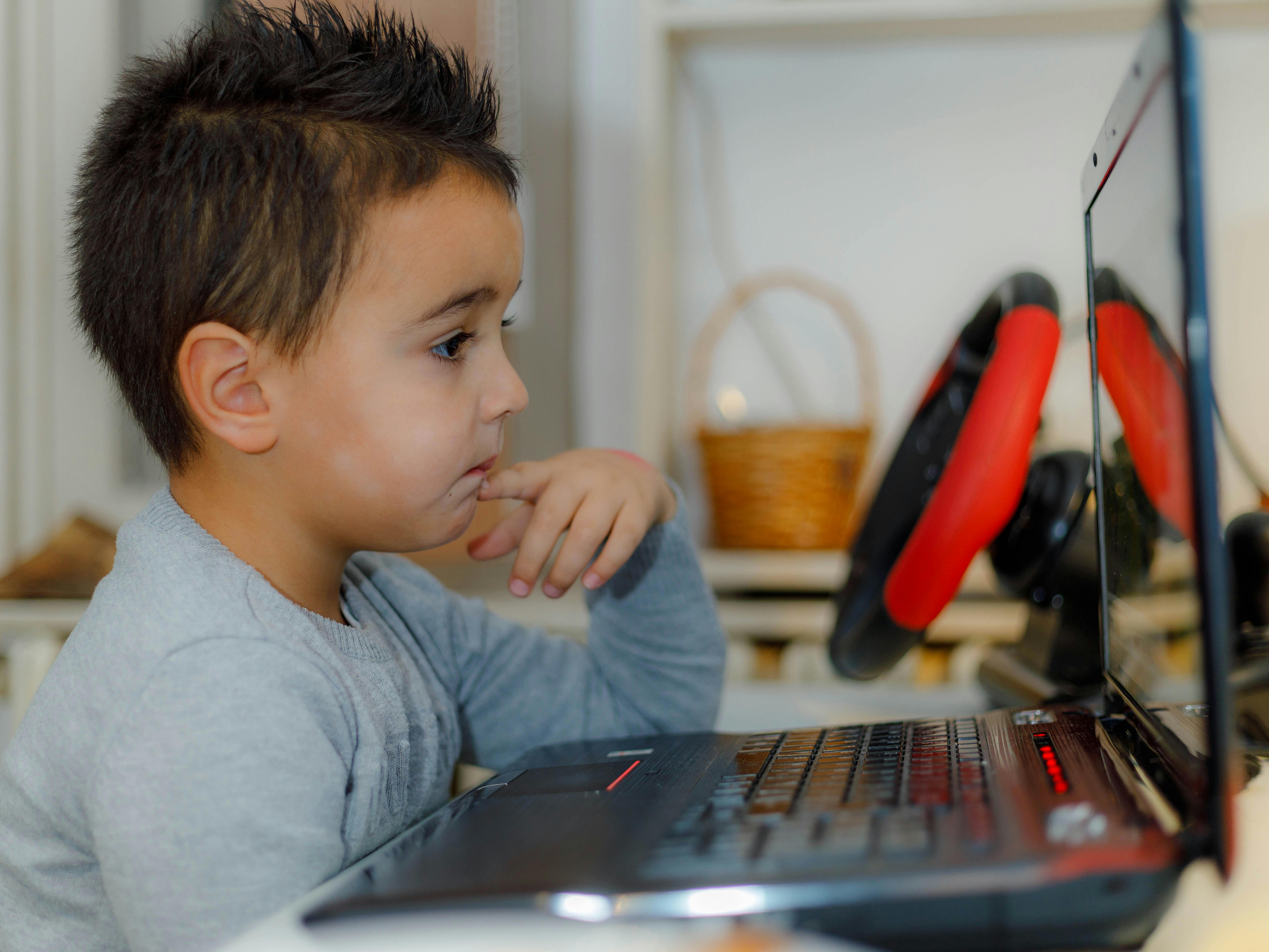 Boy Wearing Blue T Shirt Using Black Laptop Computer in a Dim Lighted ...