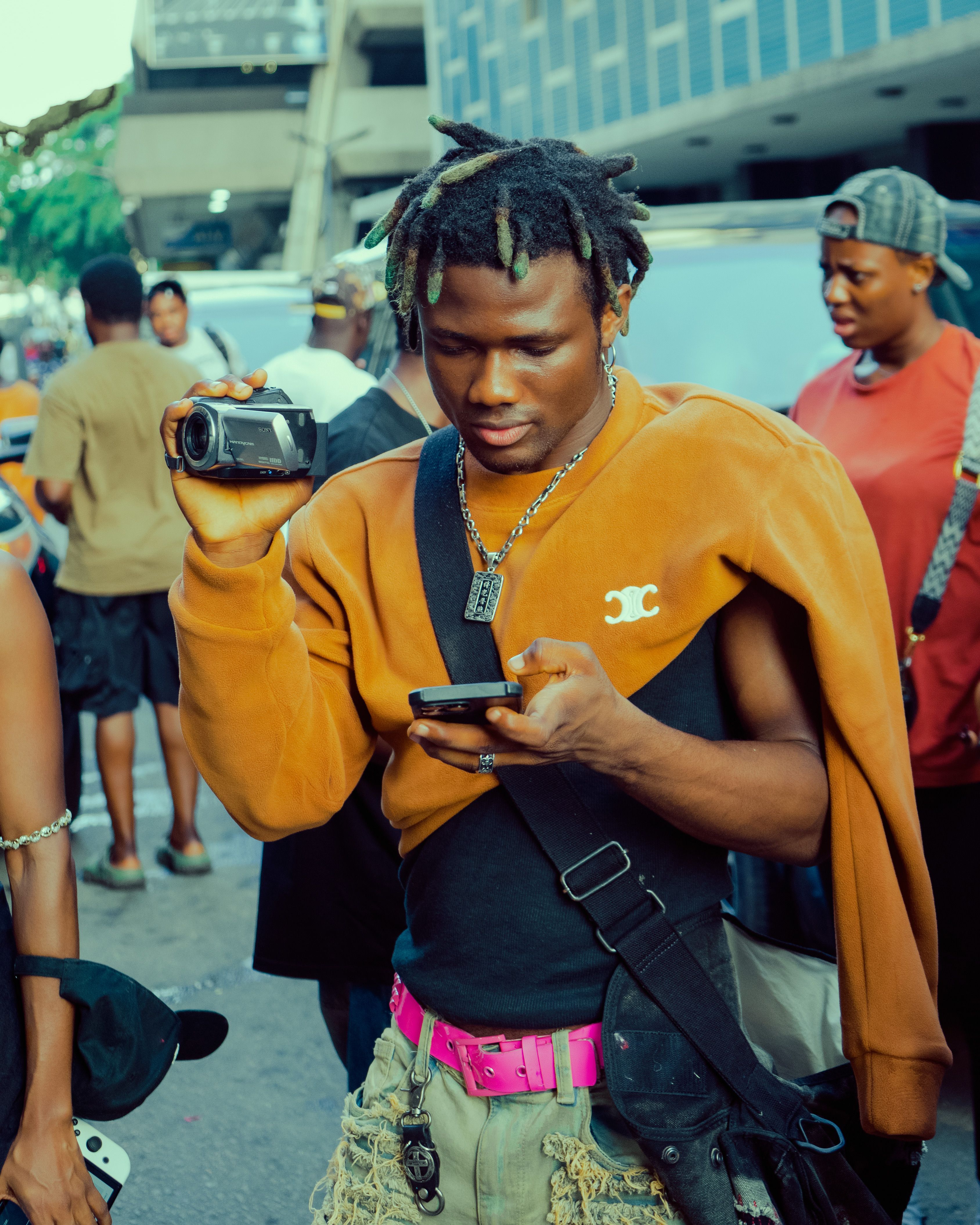 Young Man Using Camera and Smartphone Outdoors · Free Stock Photo