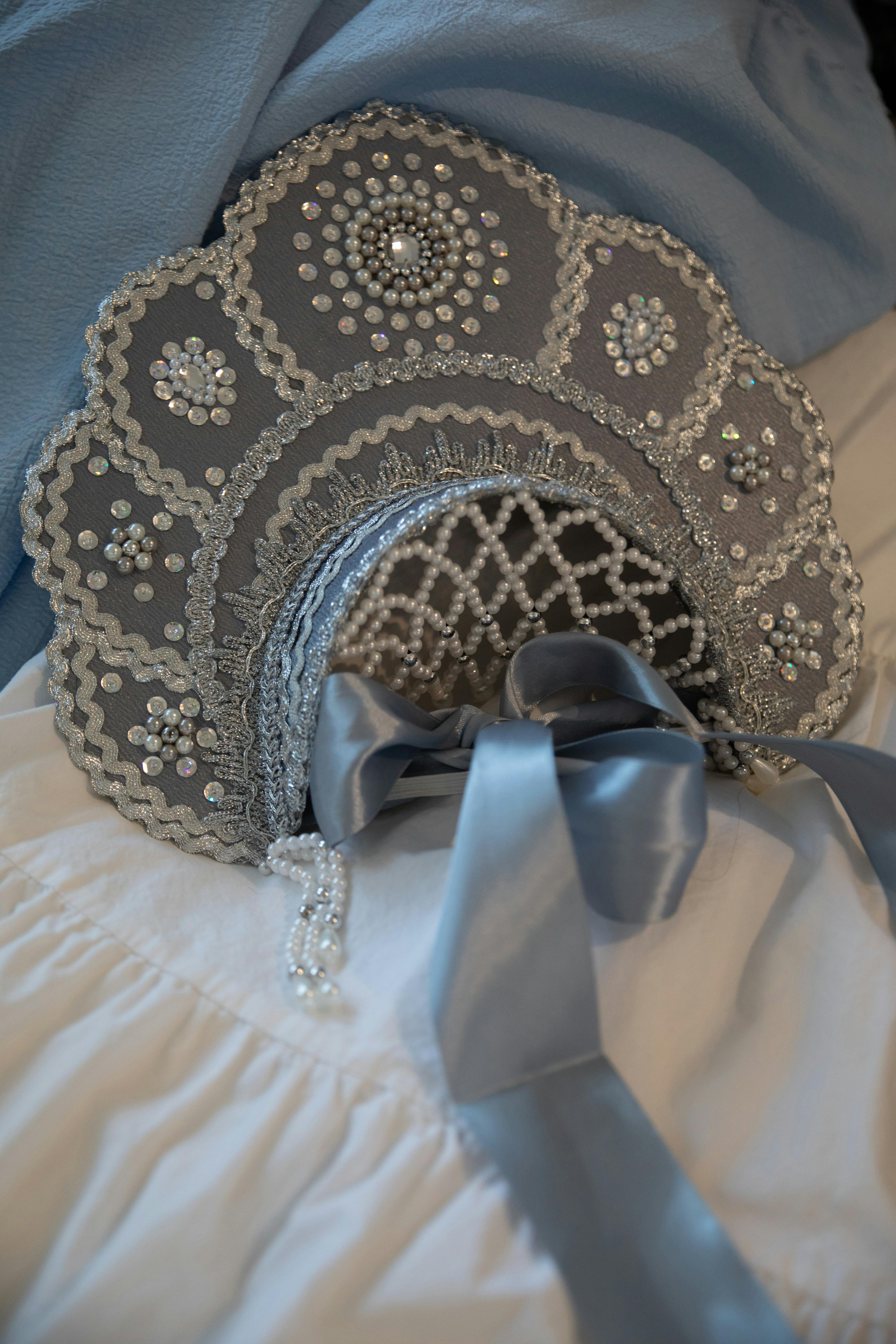 Elegant Embroidered Blue Bonnet on Soft Fabric · Free Stock Photo