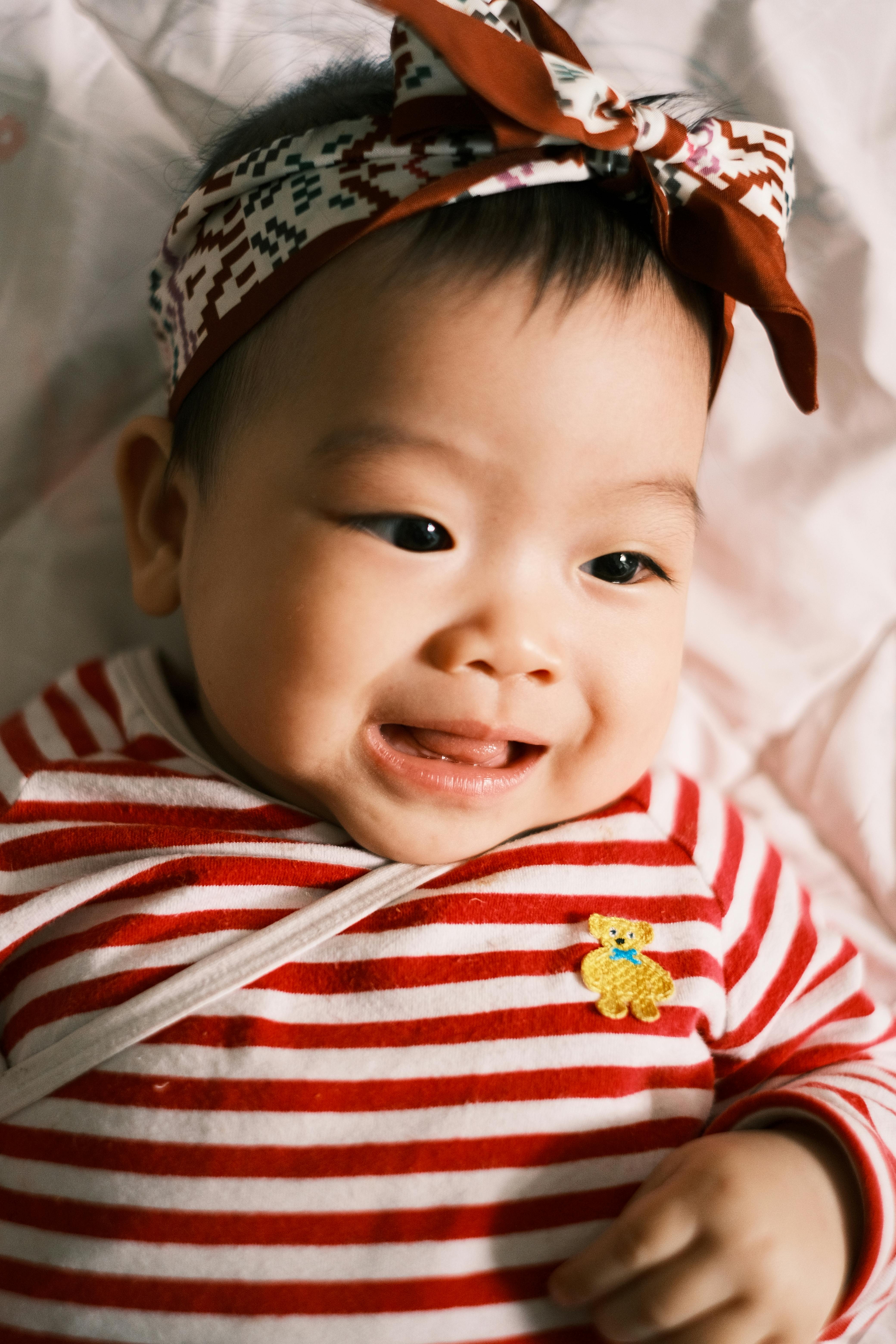 Adorable Baby Smiling in Red Striped Outfit · Free Stock Photo