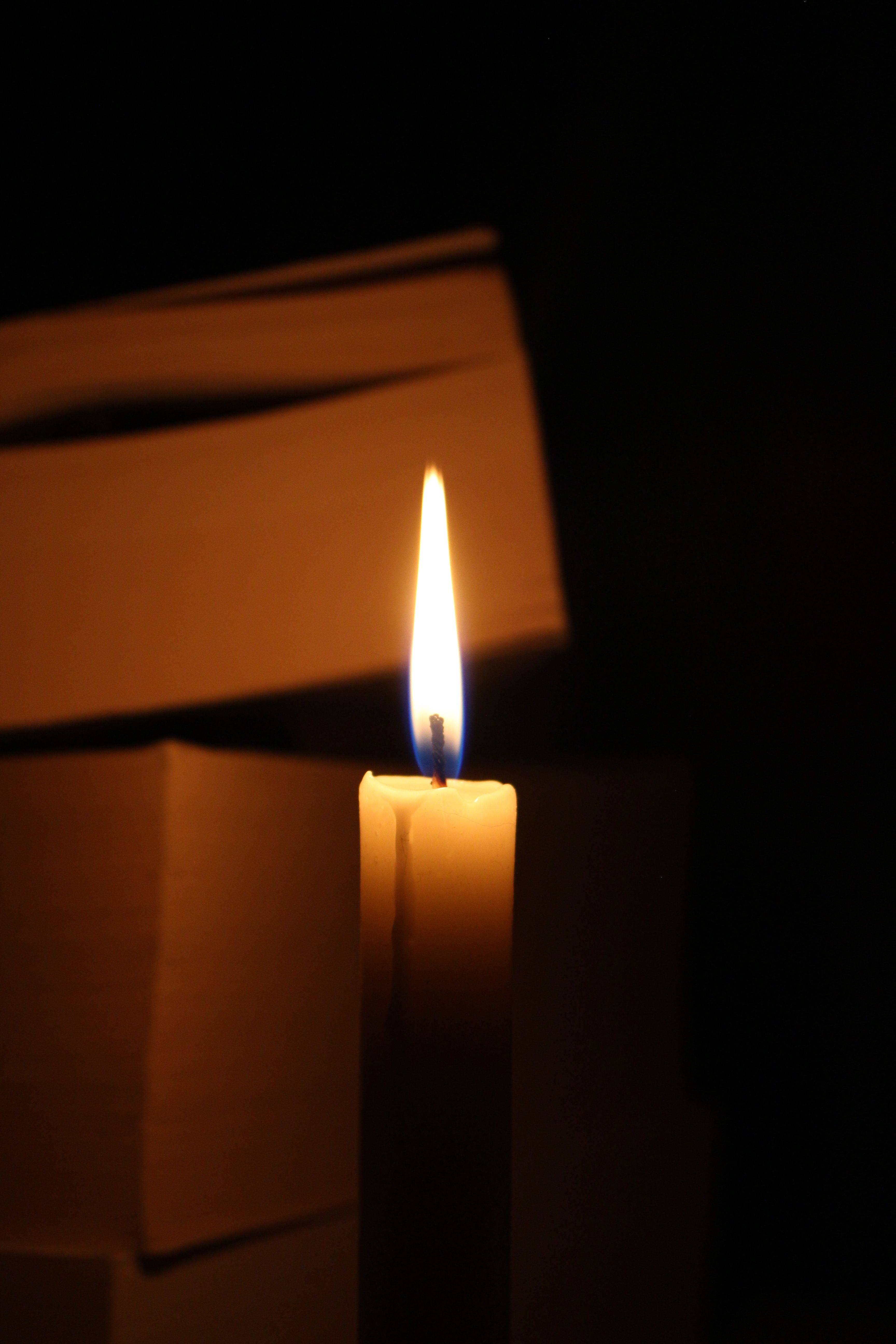 Warm Candle Lit Scene with Stack of Books · Free Stock Photo