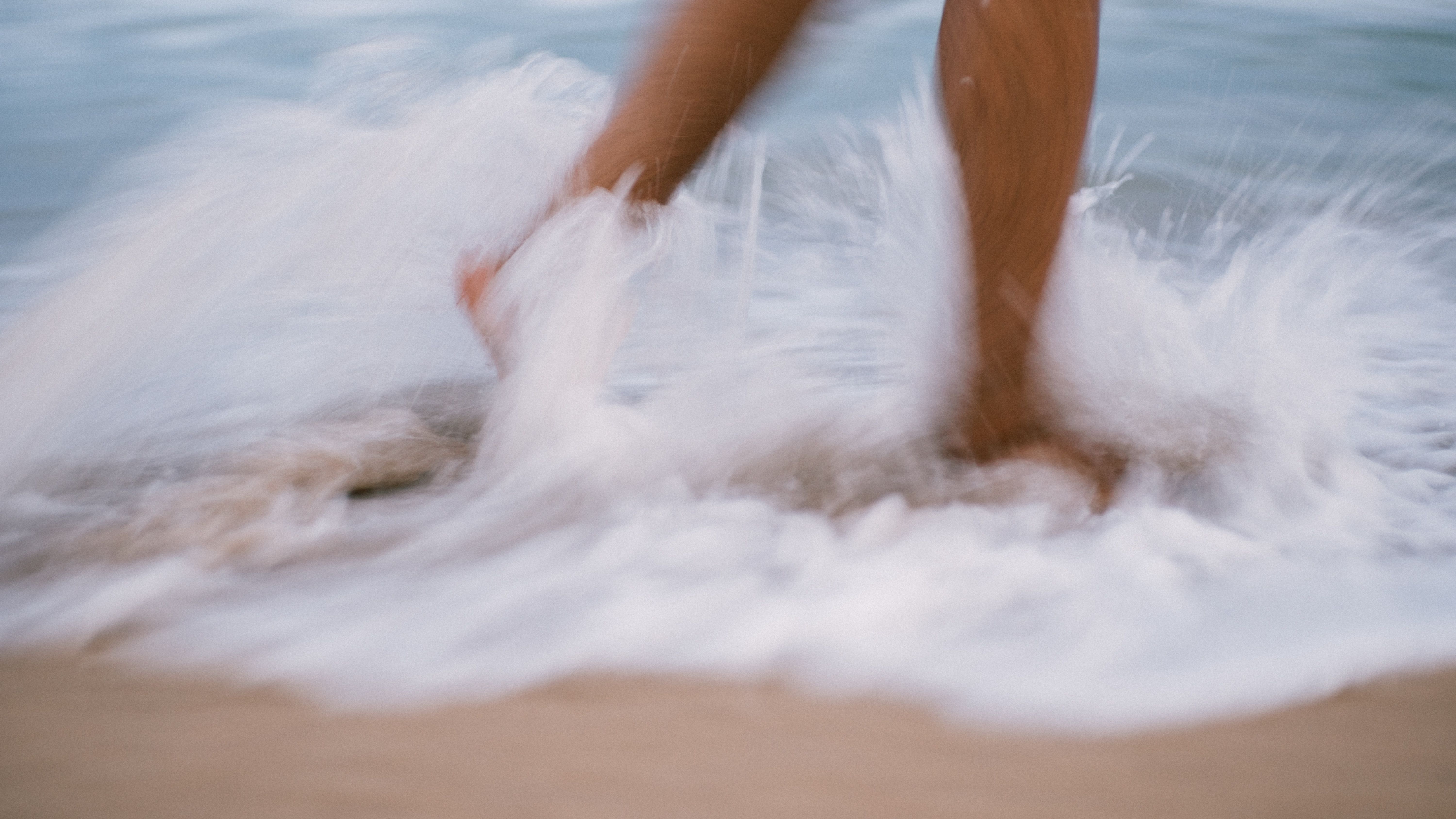Blurred Feet in Ocean Waves on Sandy Beach · Free Stock Photo