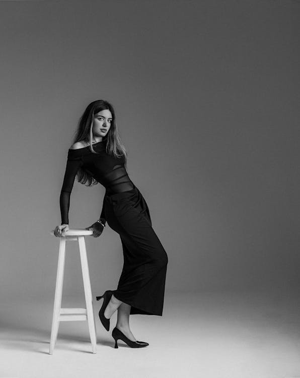 Elegante Vrouw In Zwarte Outfit Leunend Op Kruk · Gratis stockfoto Elegante Vrouw In Zwarte Outfit Leunend Op Kruk · Gratis stockfoto