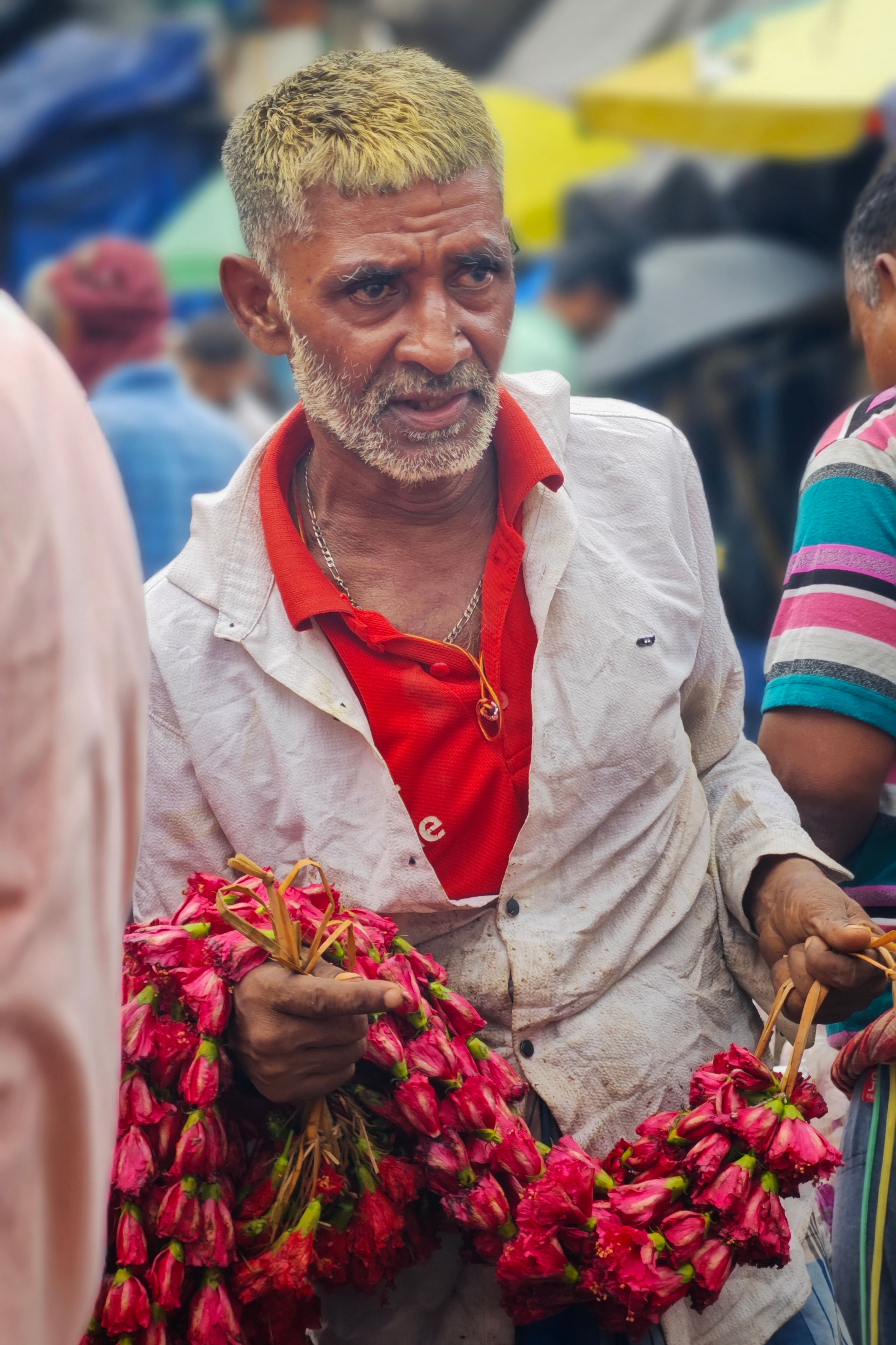 Flower Vendor at Kolkata Market Holding Fresh Blooms · Free Stock Photo