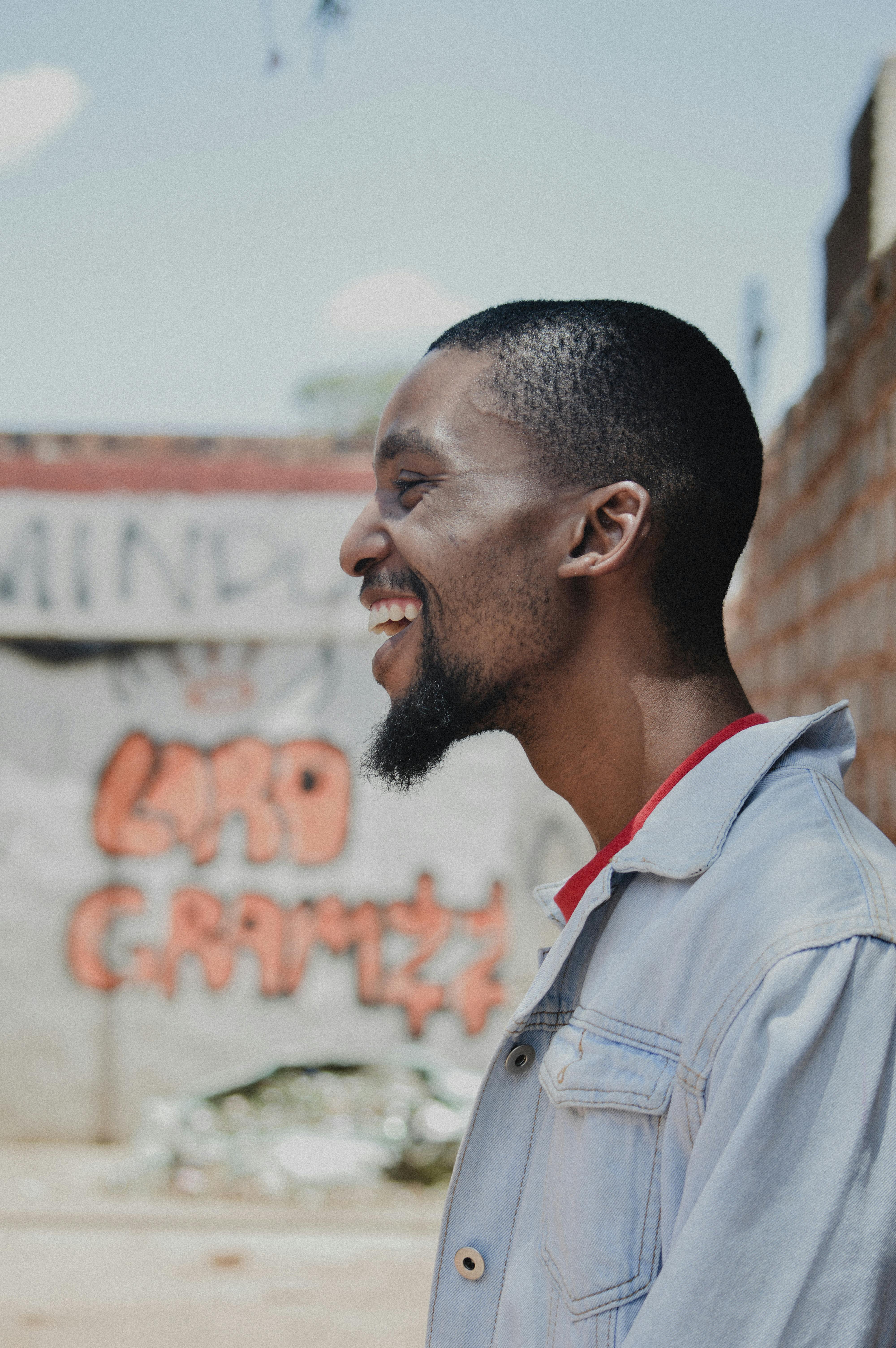 Side Profile Portrait of a Smiling Man Outdoors · Free Stock Photo
