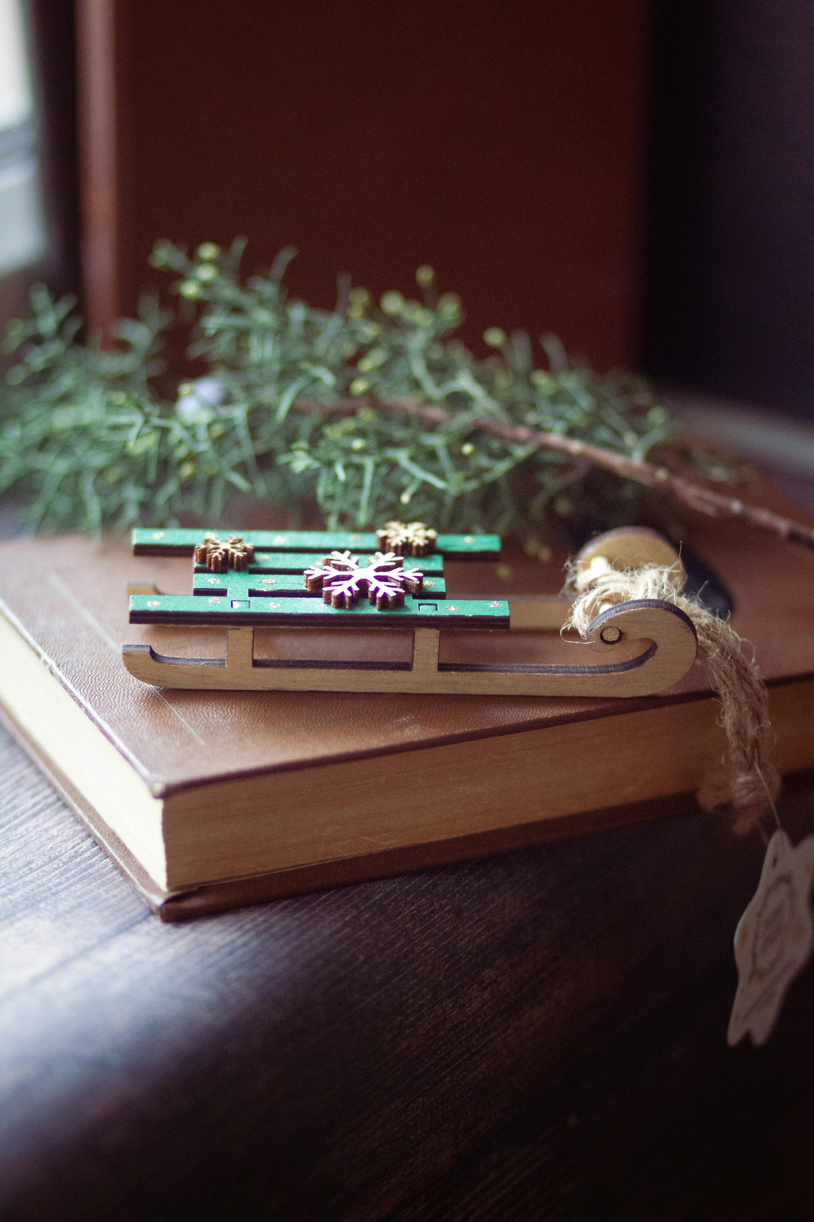 Vintage Wooden Sled on Rustic Book · Free Stock Photo