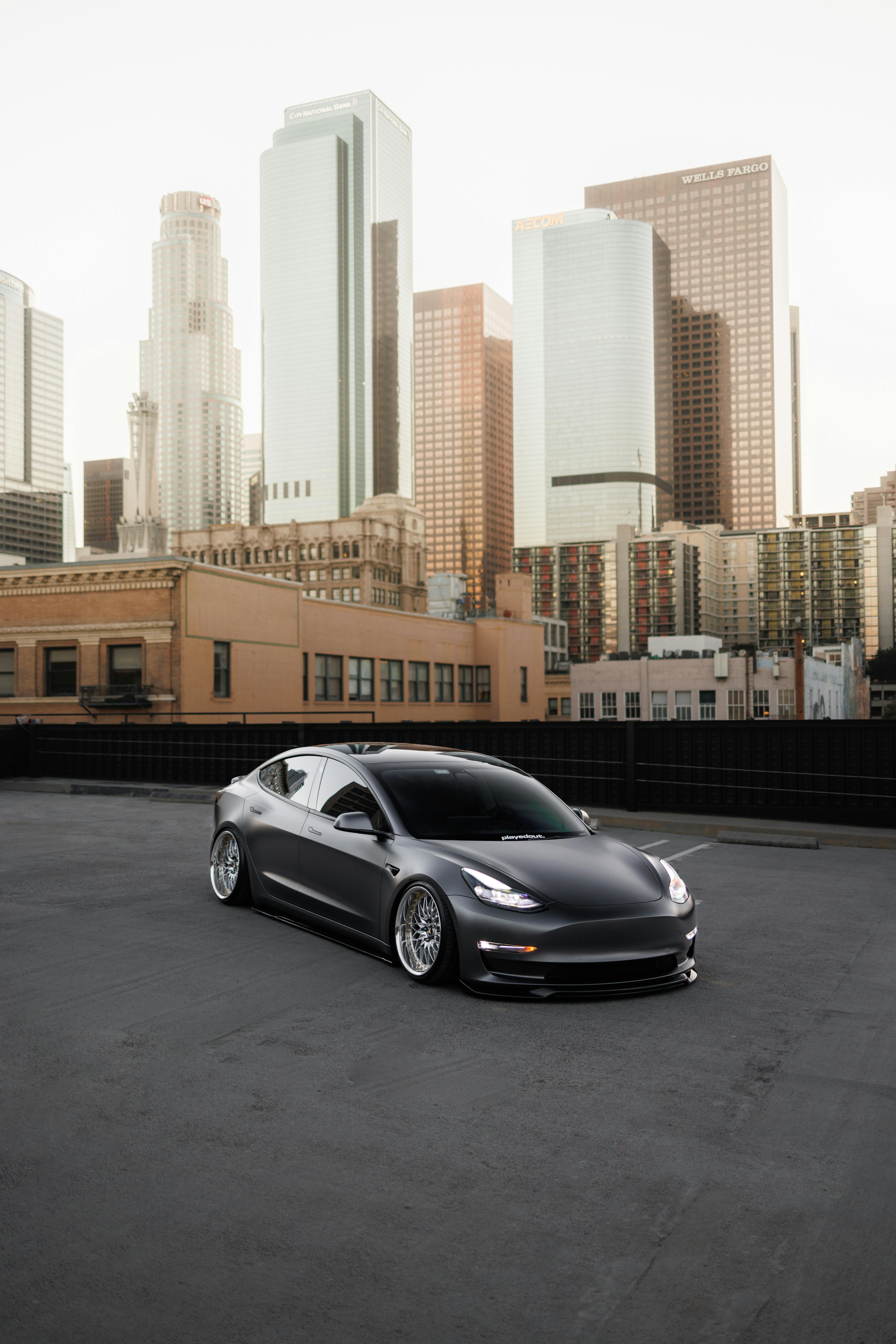 Tesla Car with Los Angeles Skyline at Sunset · Free Stock Photo