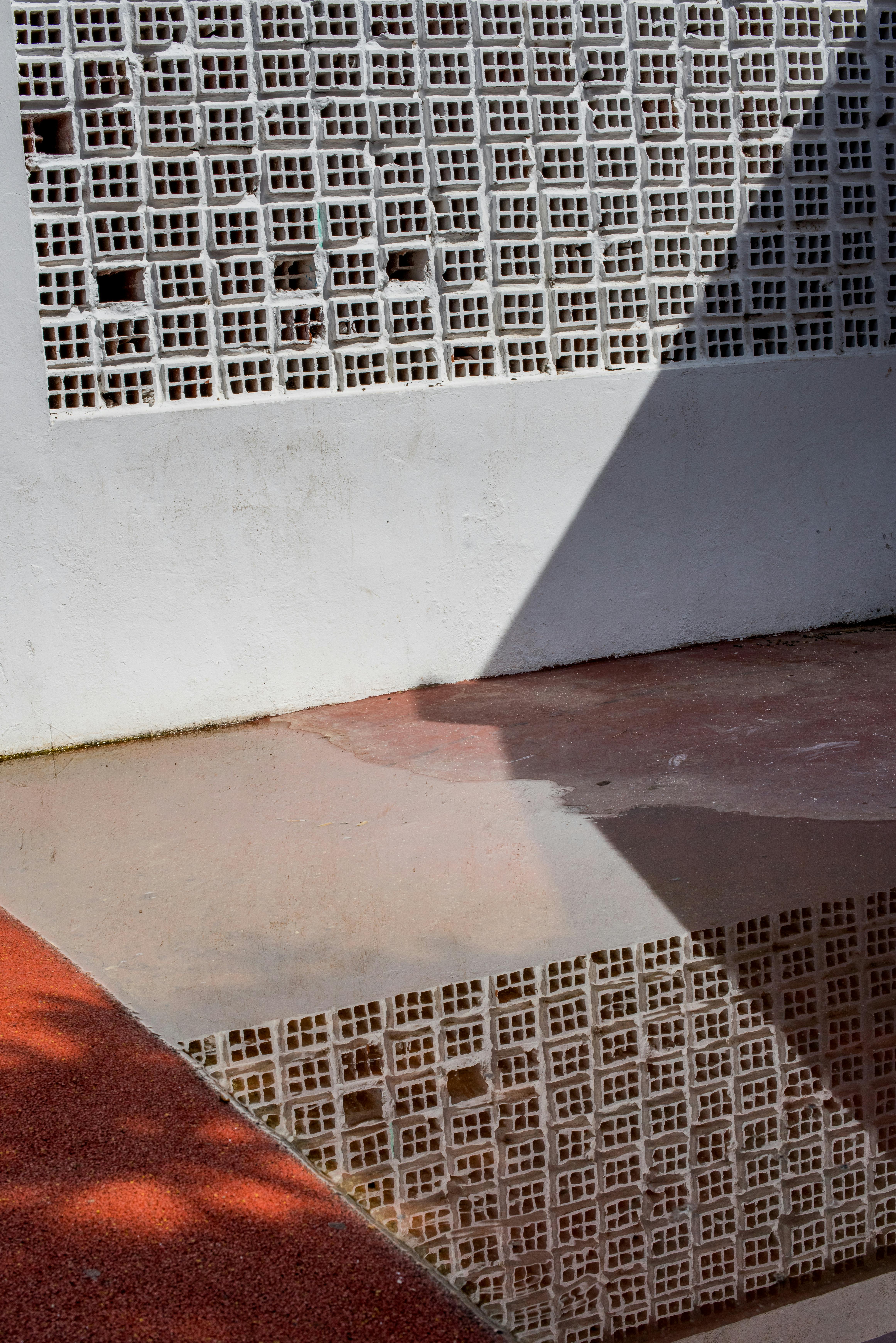 Geometric Wall Reflection in Sunlit Courtyard · Free Stock Photo