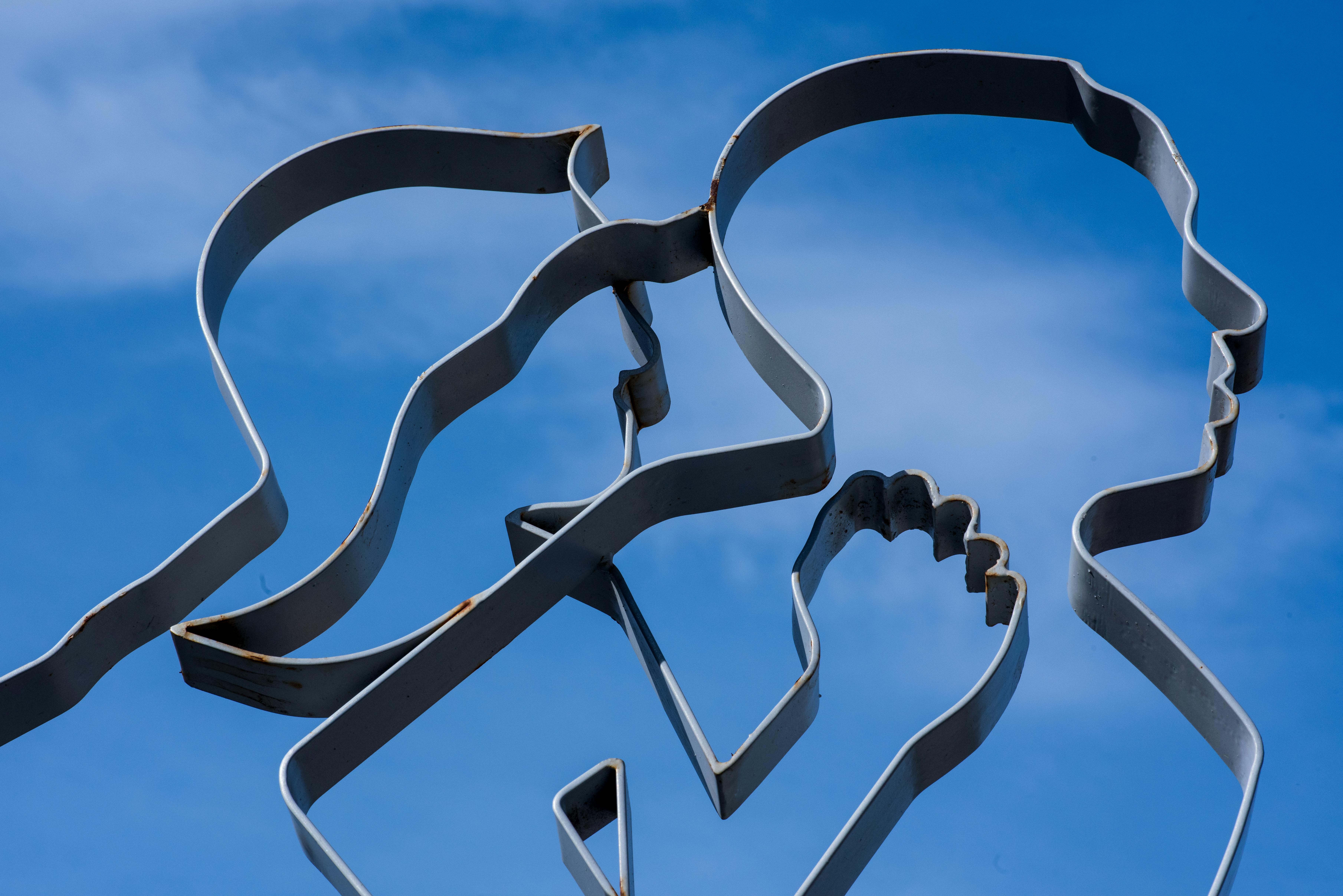 Metallic Silhouette Sculpture against Blue Sky · Free Stock Photo