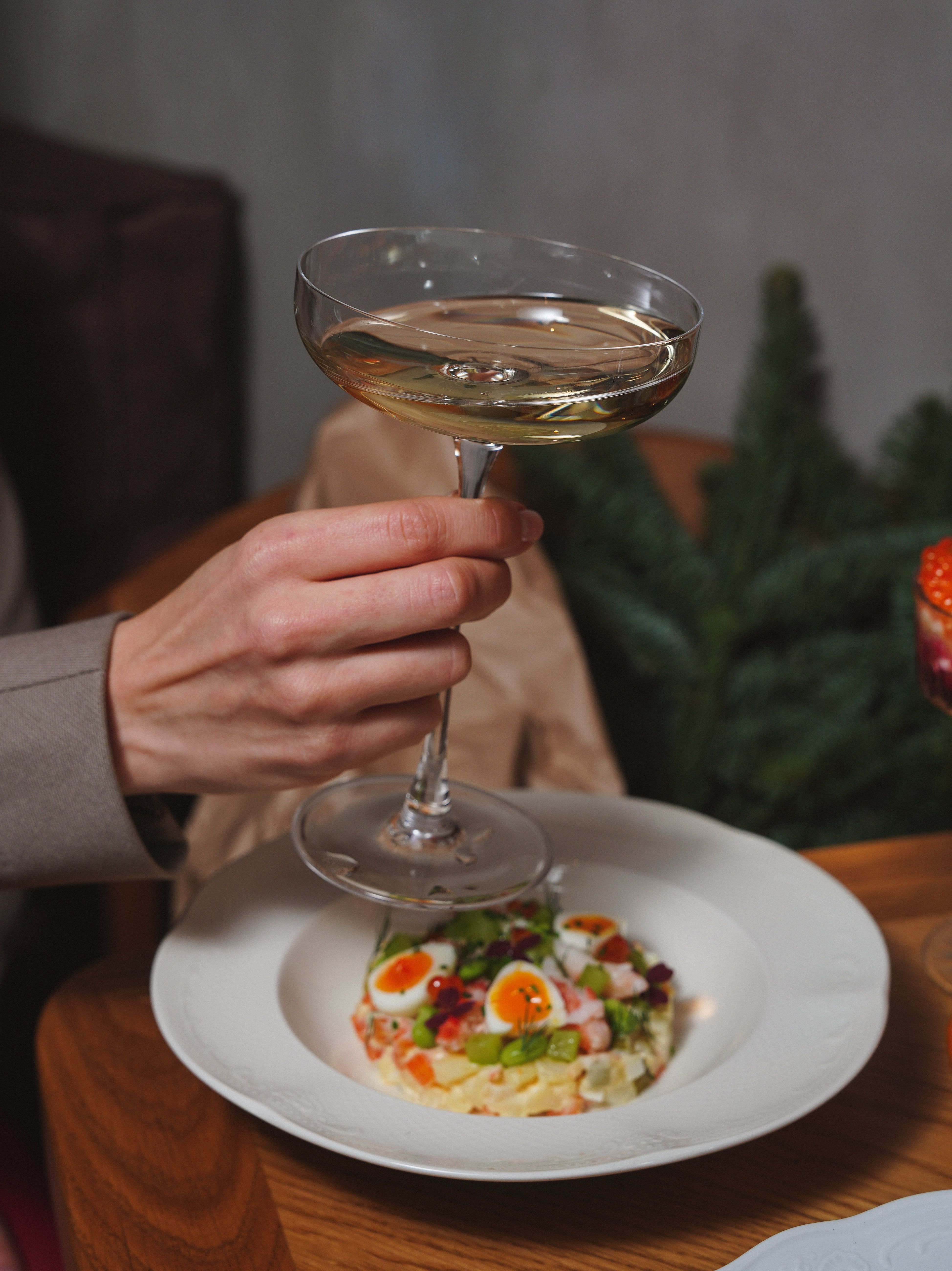 Elegant Dining: Hand Holding Champagne Glass Over Gourmet Dish · Free ...