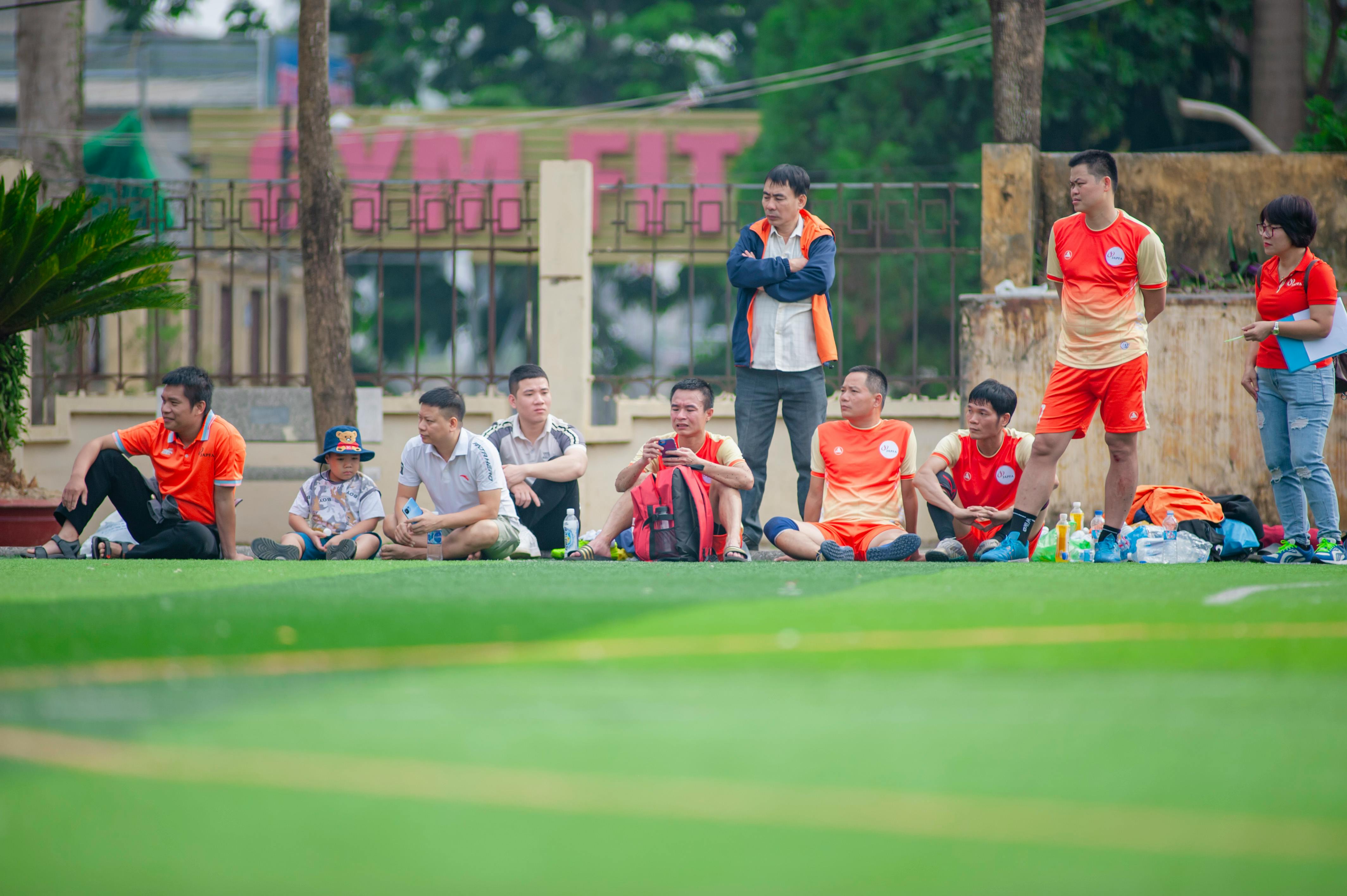 Group of People Relaxing at Outdoor Sports Ground · Free Stock Photo