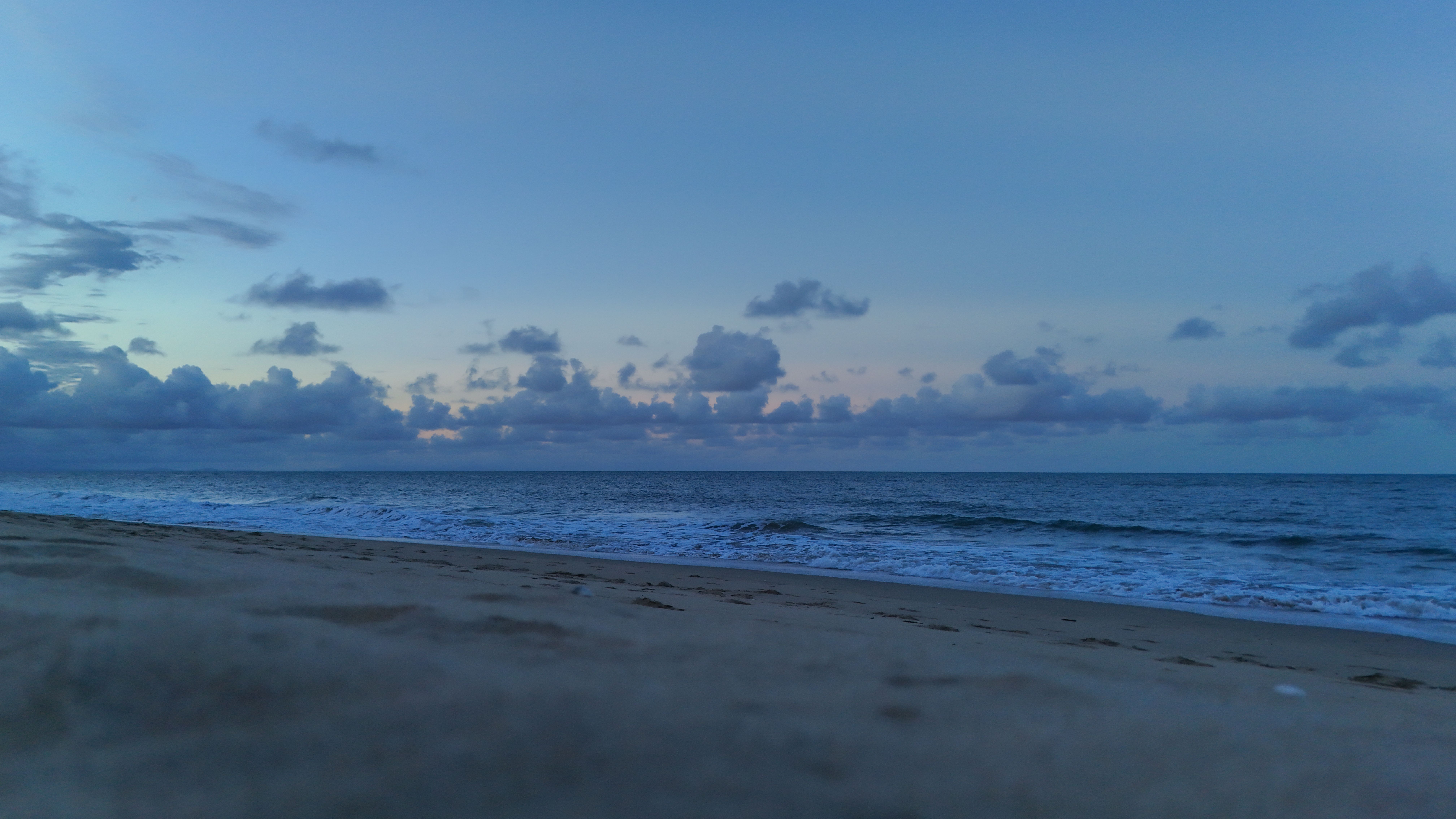 Serene Beach at Twilight with Calm Waves · Free Stock Photo