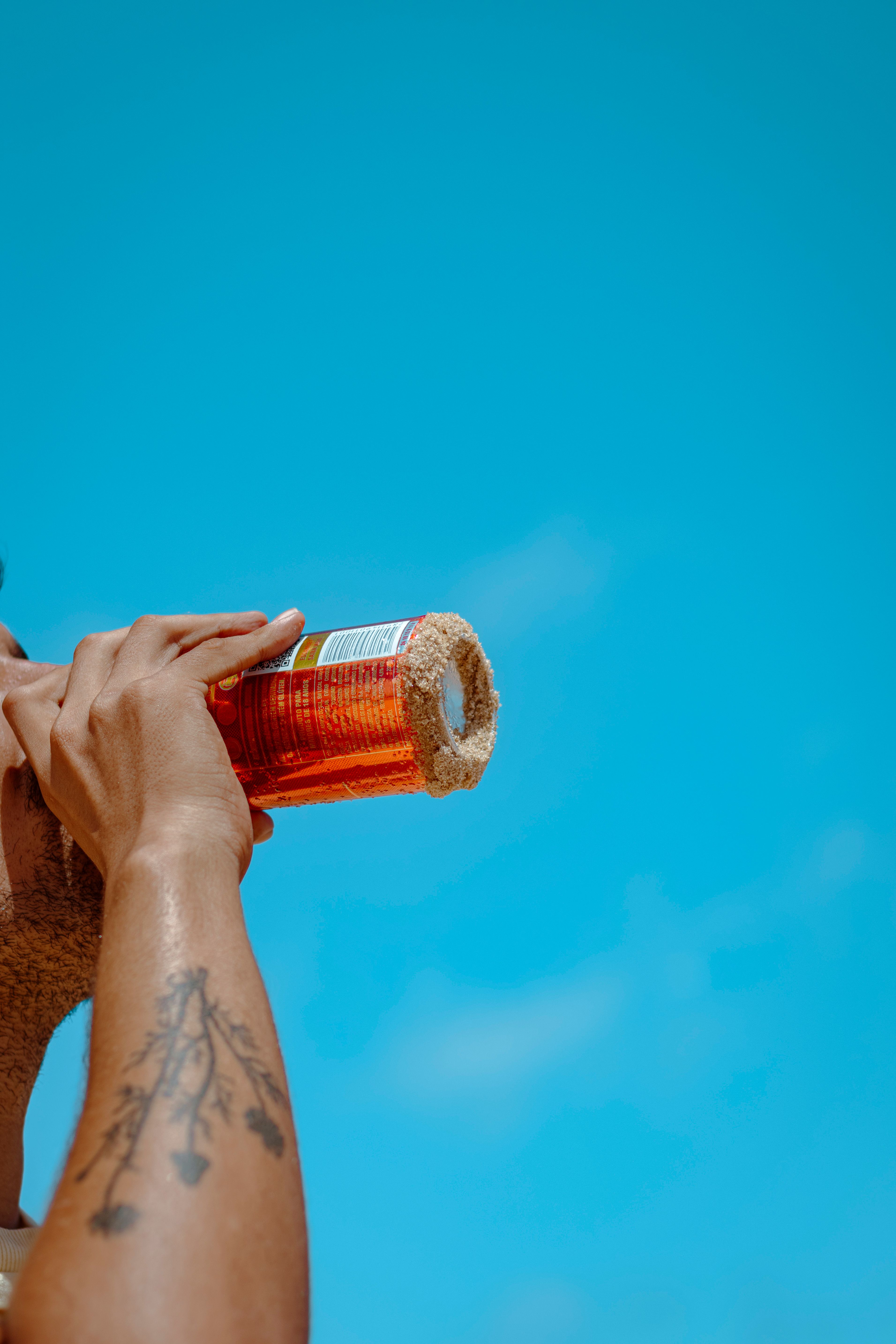 Unique Perspective of Person Drinking with Clear Sky · Free Stock Photo
