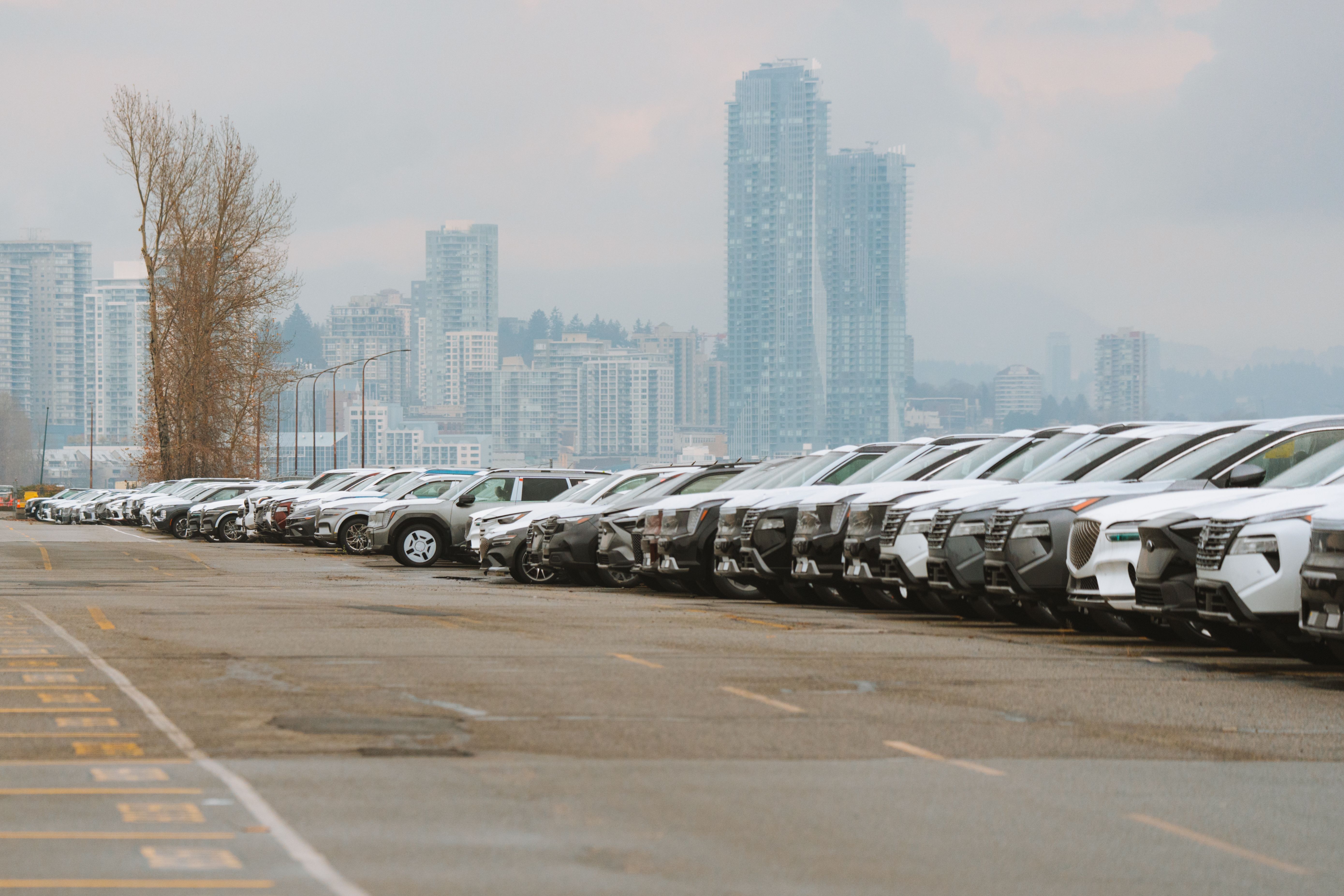 City Skyline with Parked Cars in Urban Parking Lot · Free Stock Photo