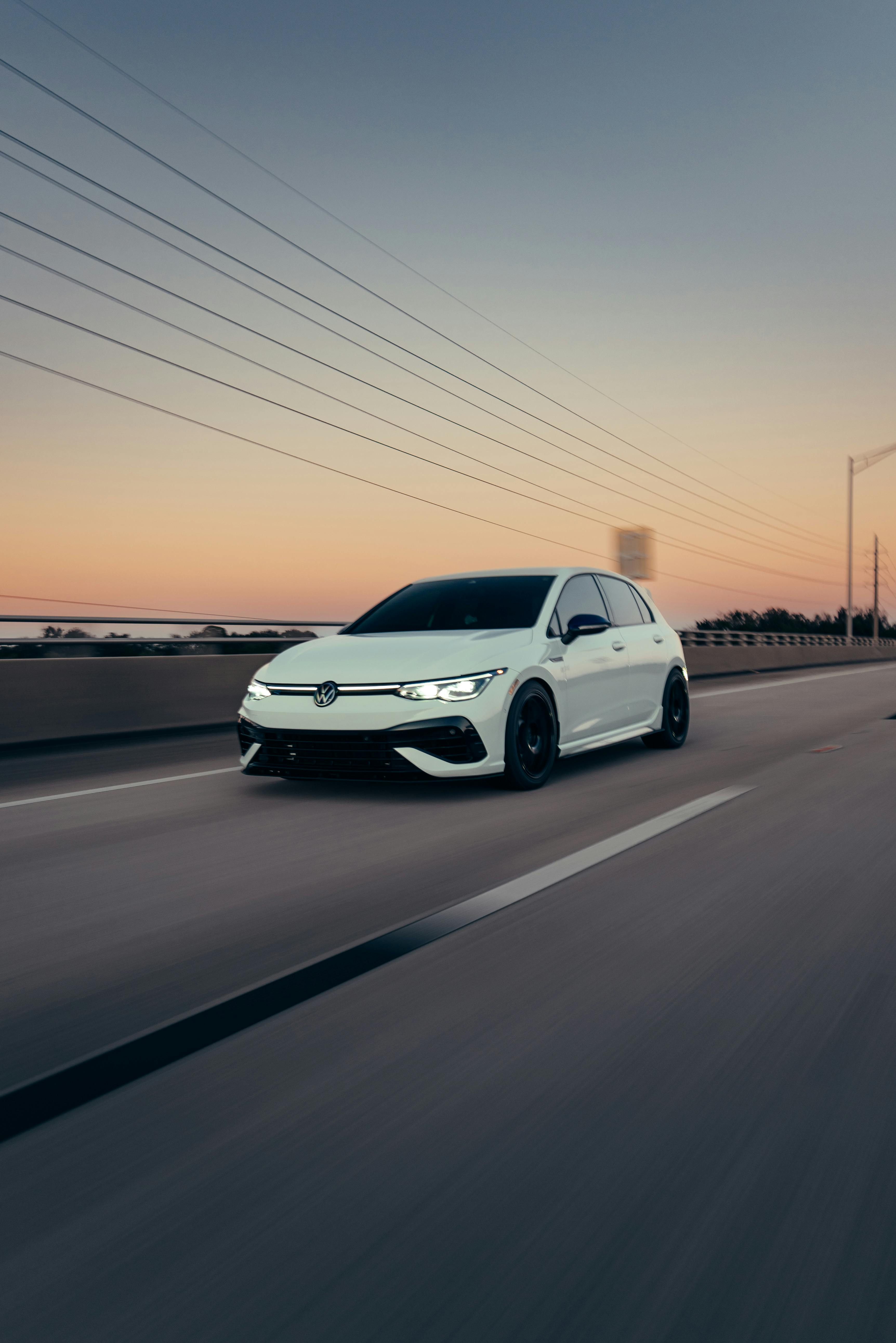 Sleek White Car on Highway at Sunset · Free Stock Photo