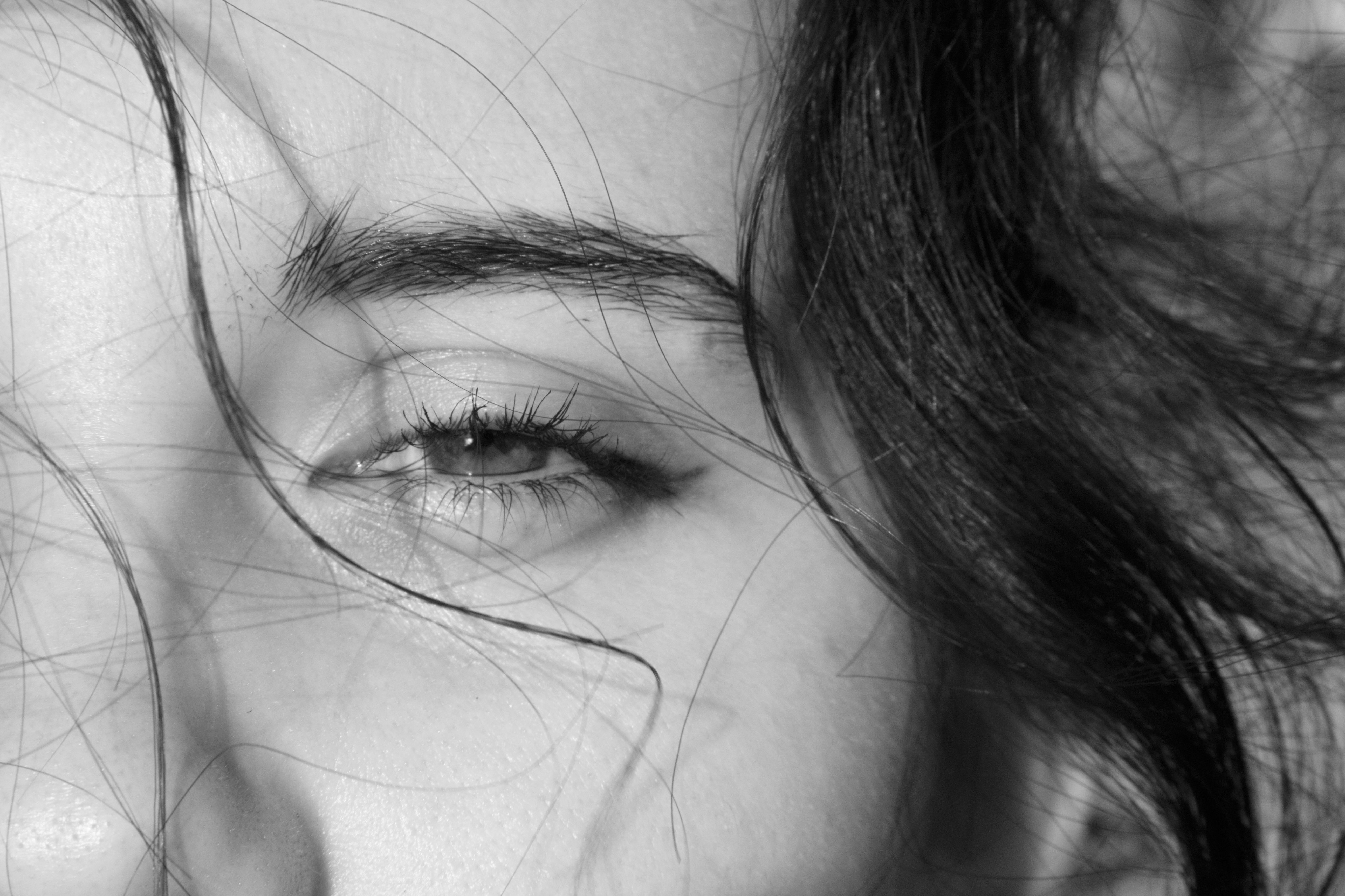 Artistic Close-Up of Woman's Eye with Hair · Free Stock Photo