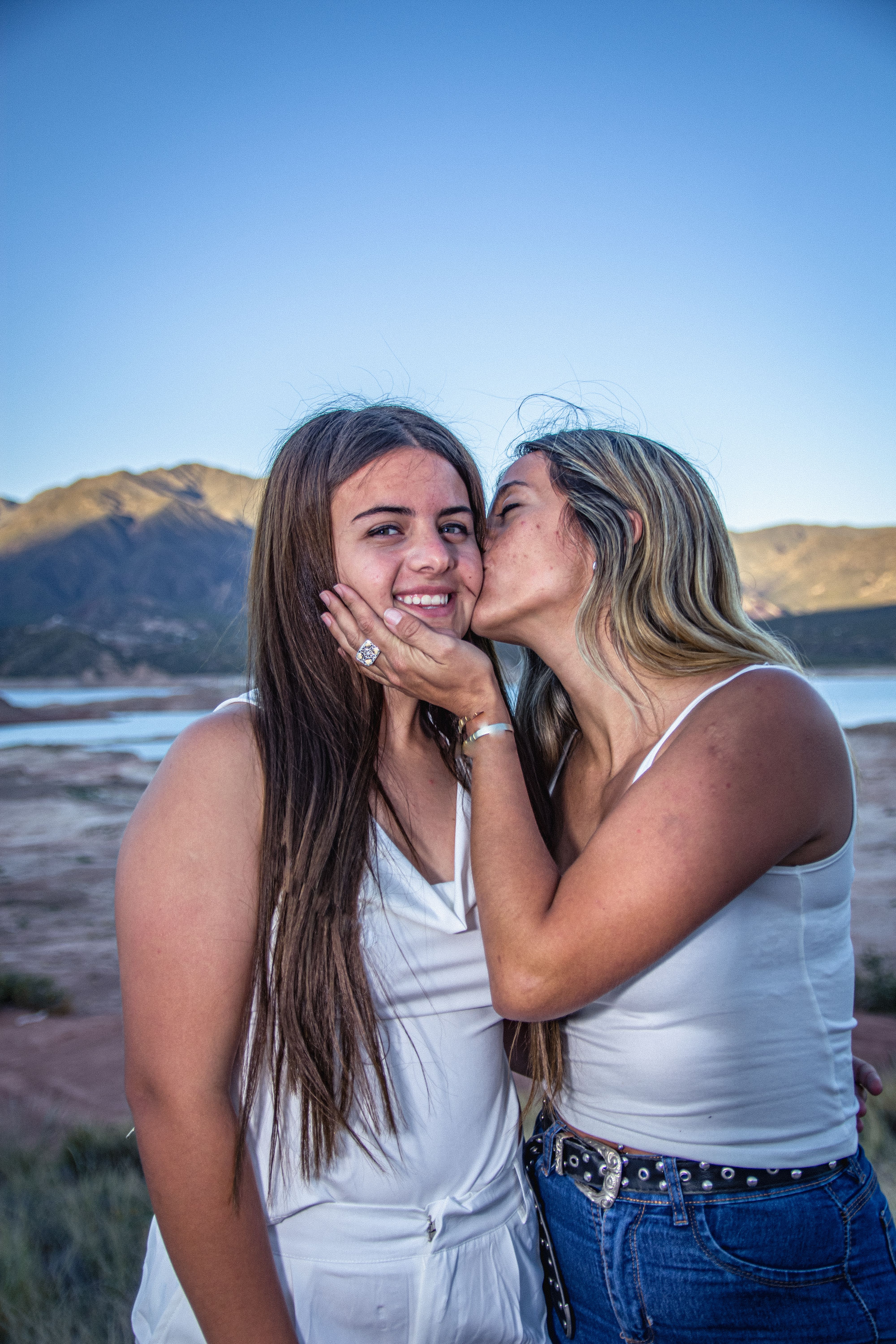 Two Friends Enjoying a Scenic Lakeside View · Free Stock Photo