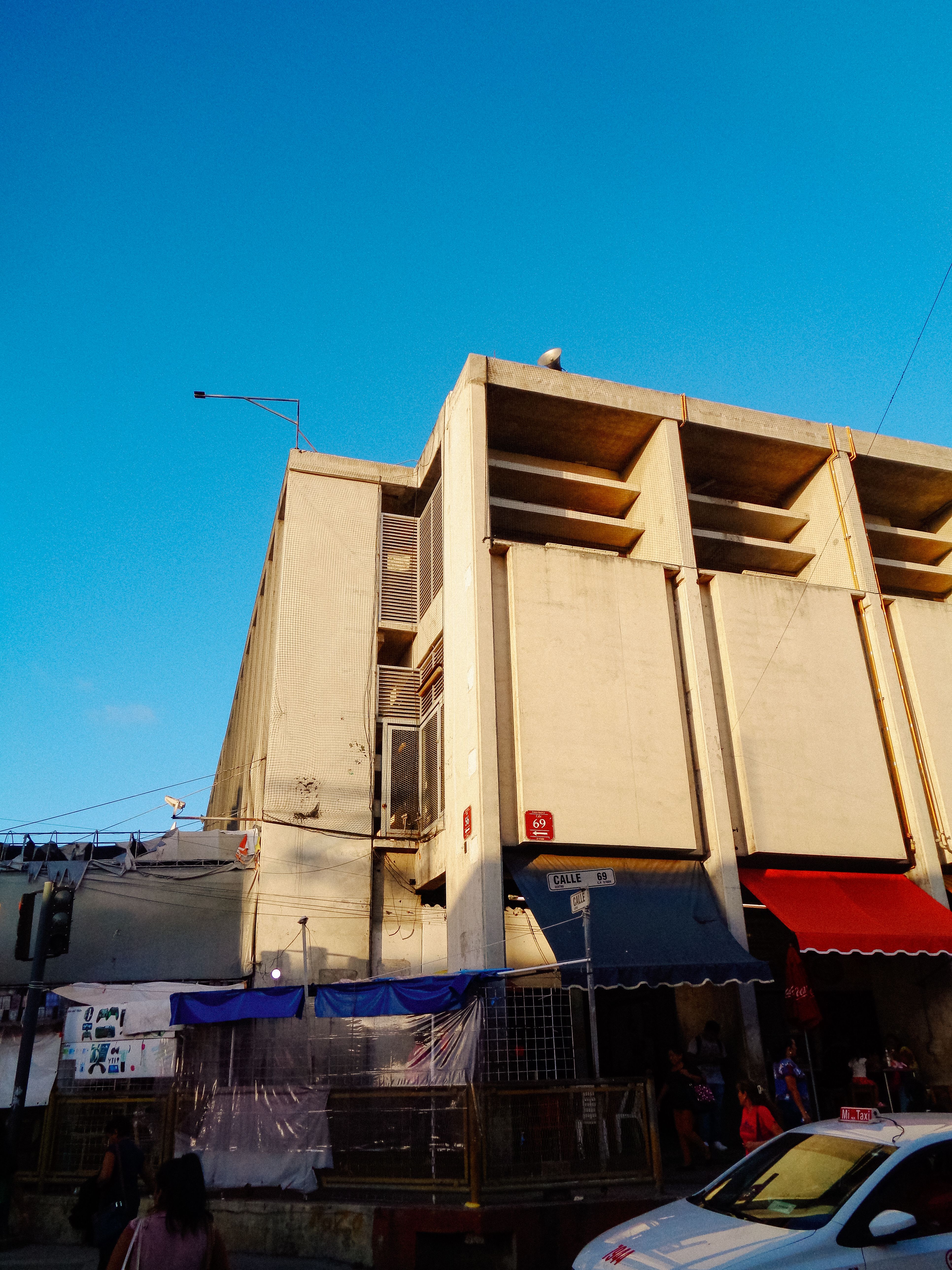 Urban Street Scene with Concrete Building and Market · Free Stock Photo